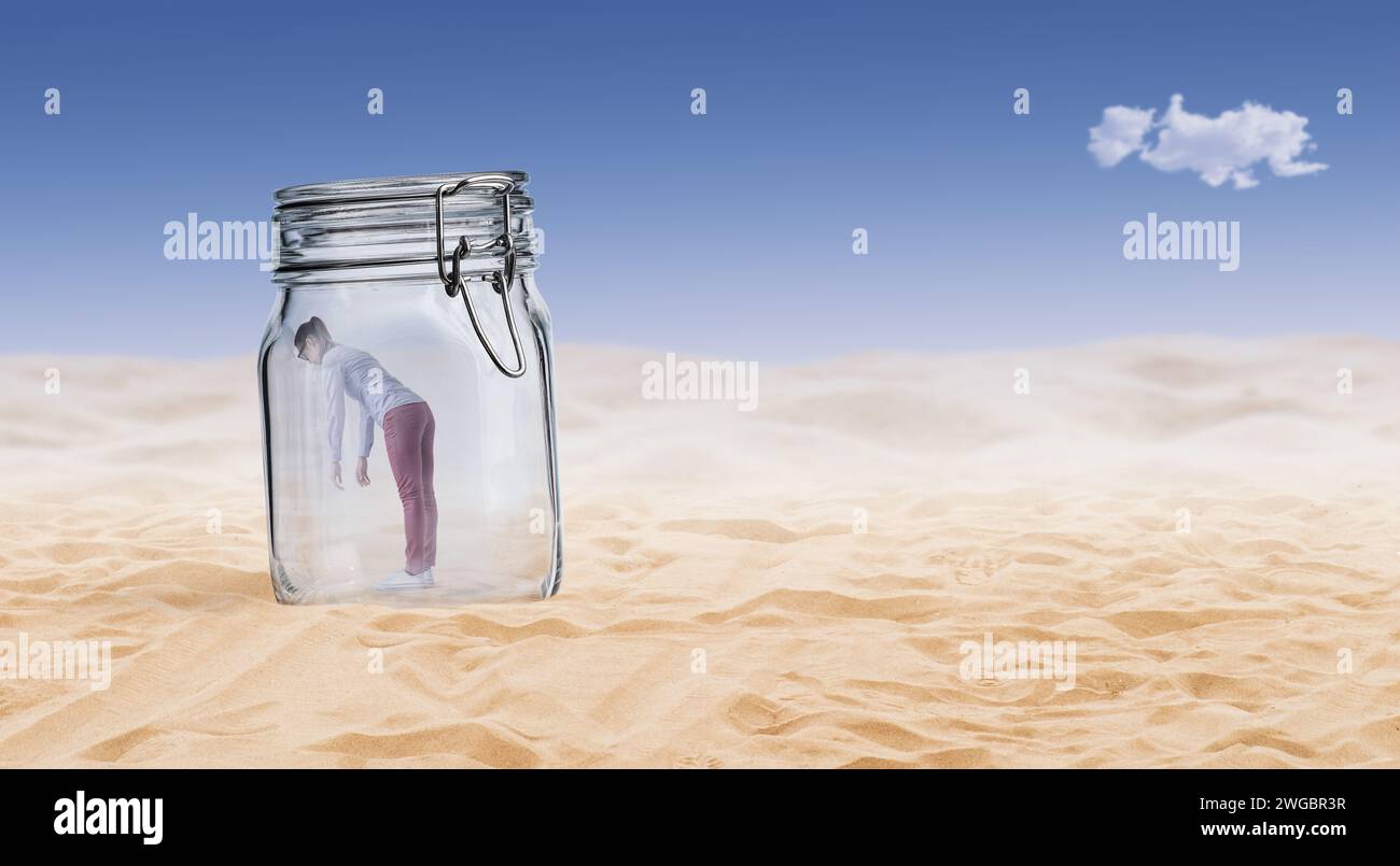 Desperate young woman trapped in a glass jar in the desert Stock Photo - Alamy