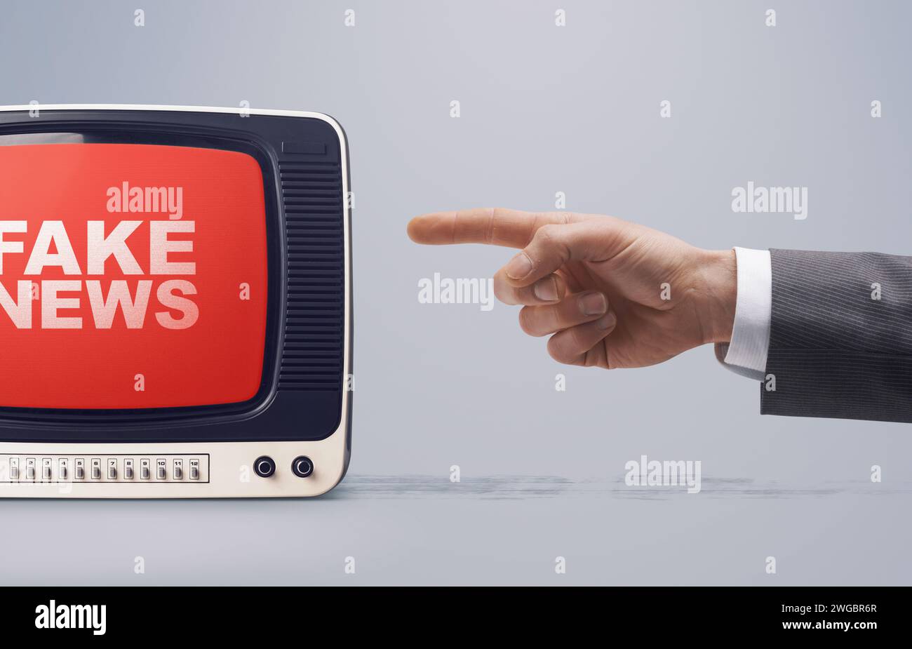 Hand pointing at an old television broadcasting false information: fake ...