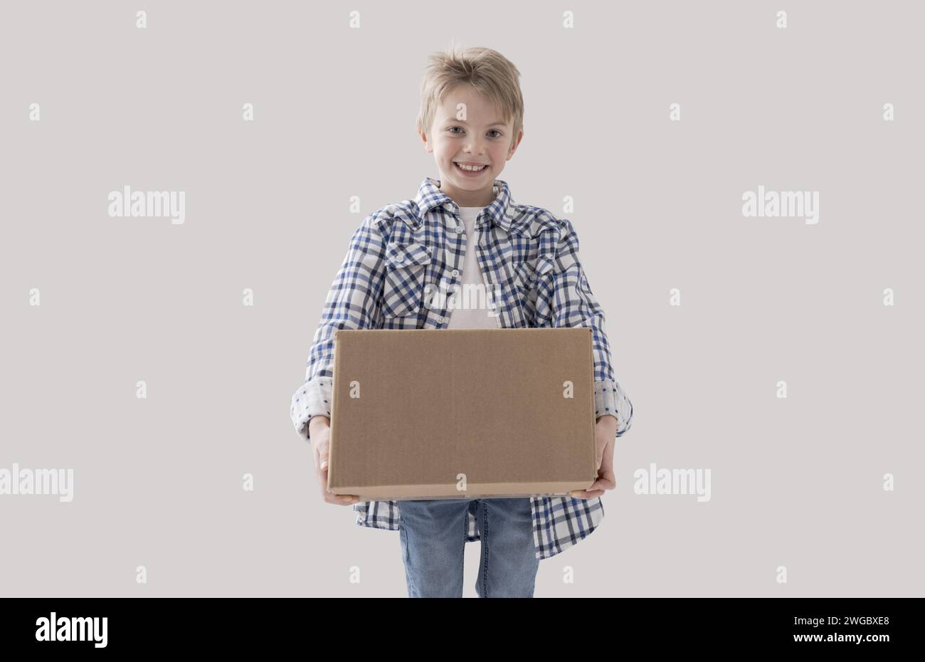 Happy strong boy holding a big cardboard box, delivery and home ...