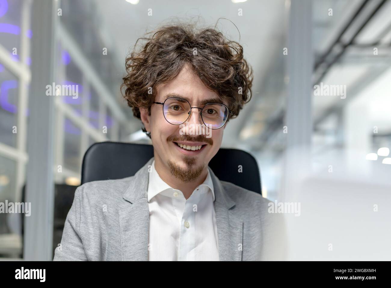 Close-up portrait of a smiling young businessman, developer man in a ...