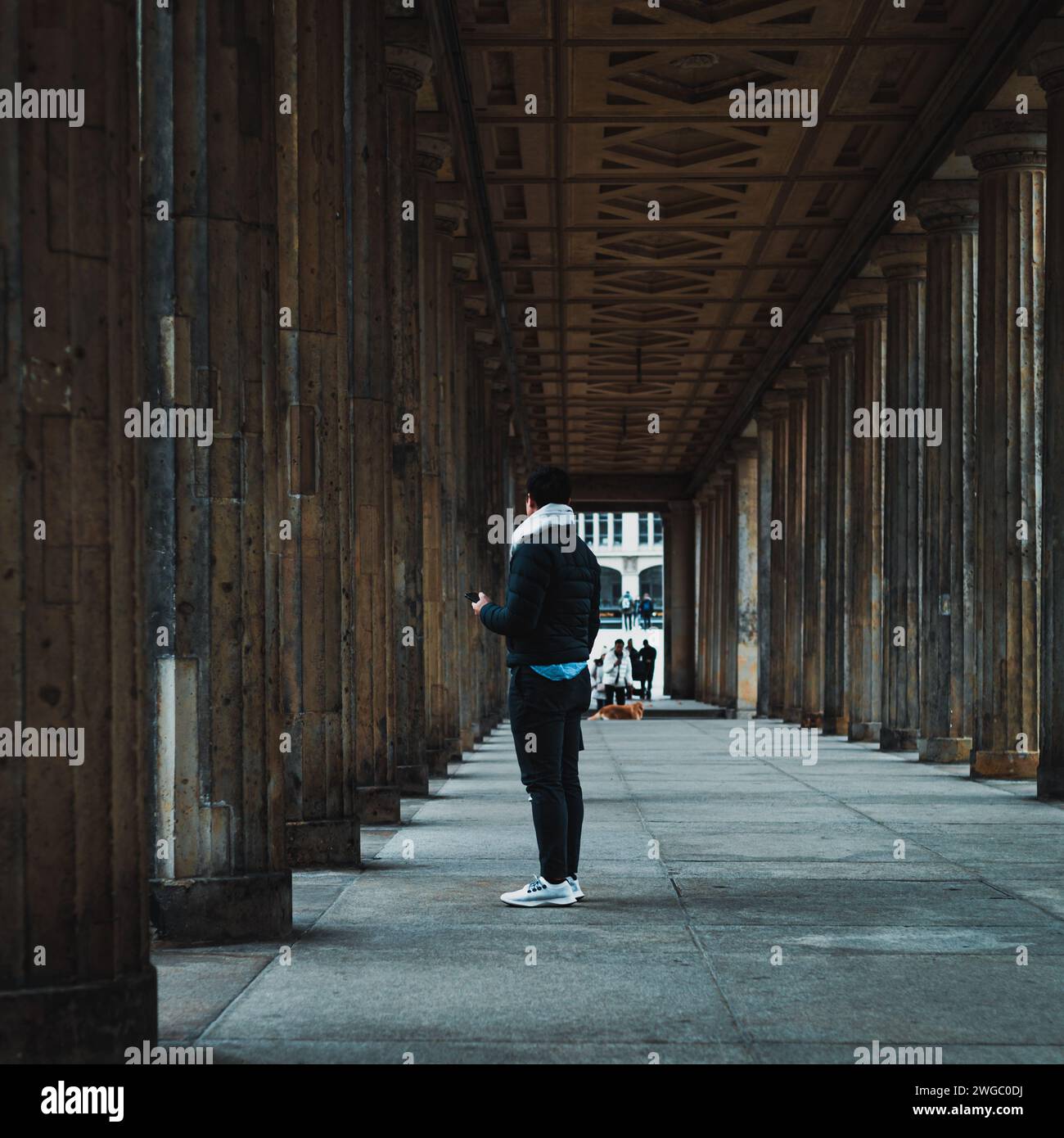 man at passage between columns in Berlin city Stock Photo - Alamy