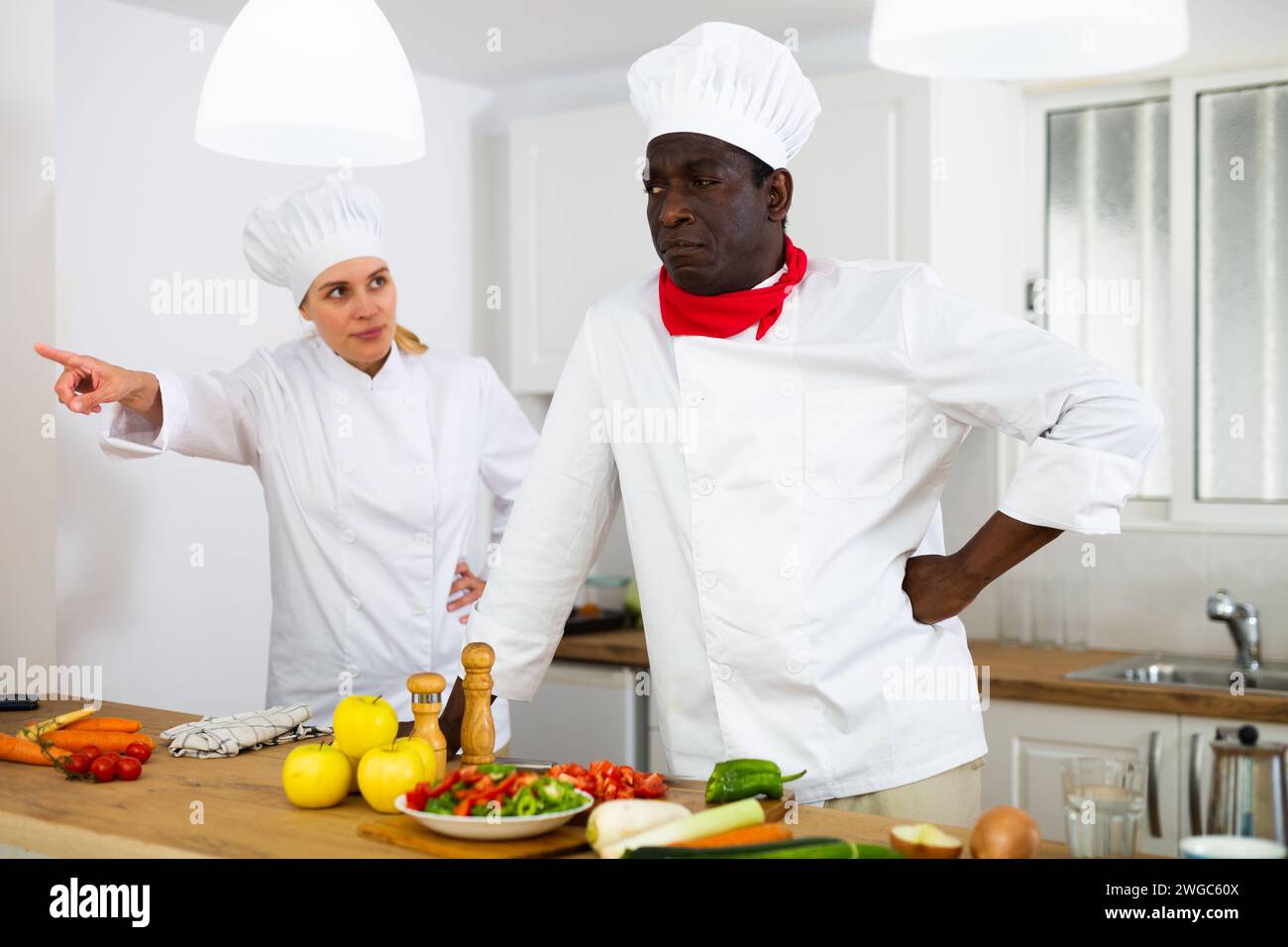 Chefs in white uniform having conflict on kitchen Stock Photo - Alamy