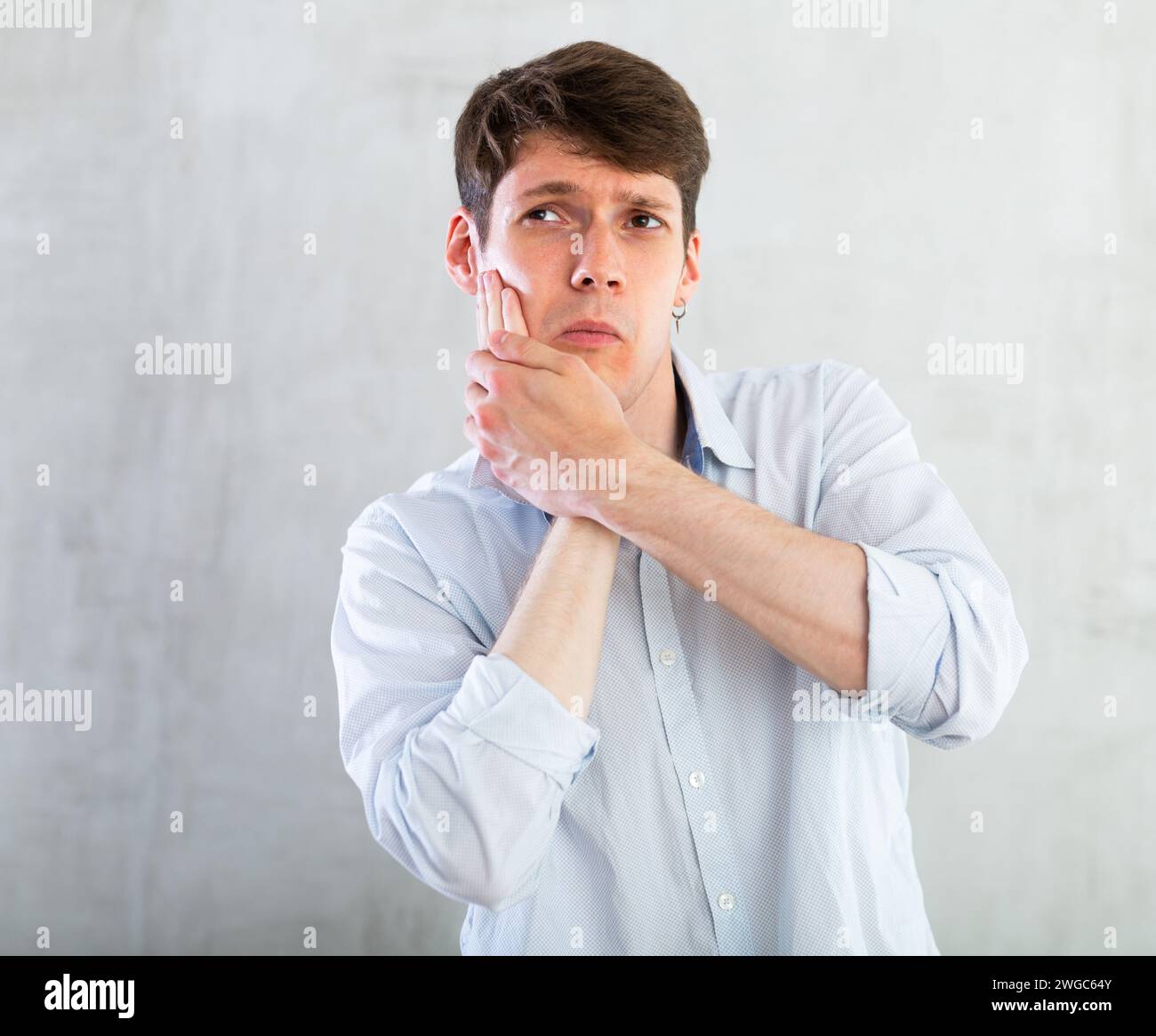 Young guy holding his cheek with toothache Stock Photo - Alamy