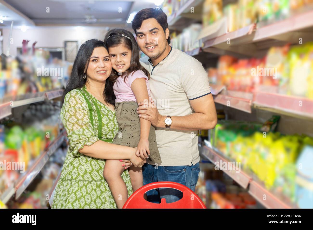Portrait of Happy indian family of three shopping for groceries at the ...