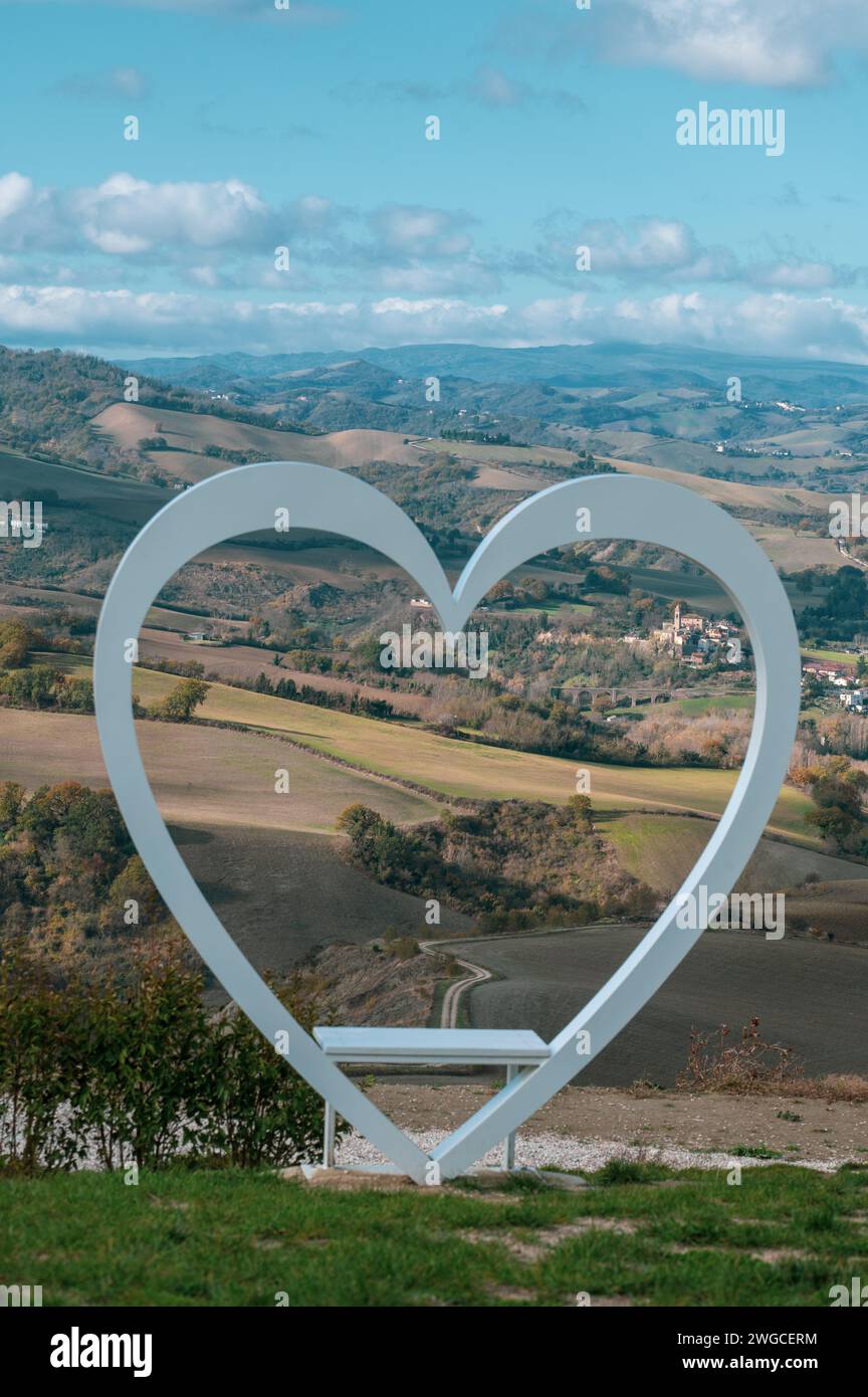 A heart shape sign at a scenic overlook with fields in the background ...