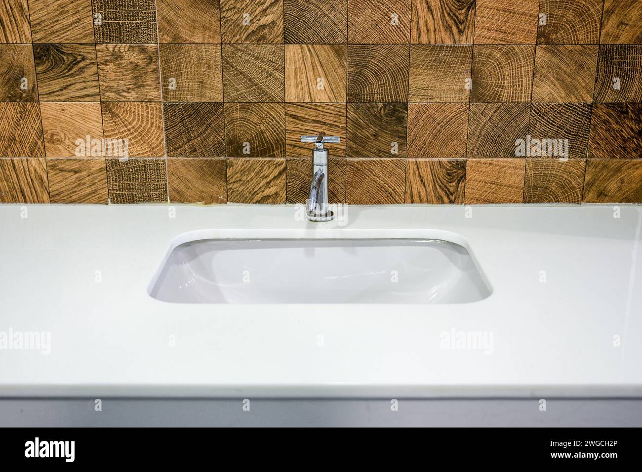 Silver Water tap with white ceramic basin on wood tiles in restroom ...