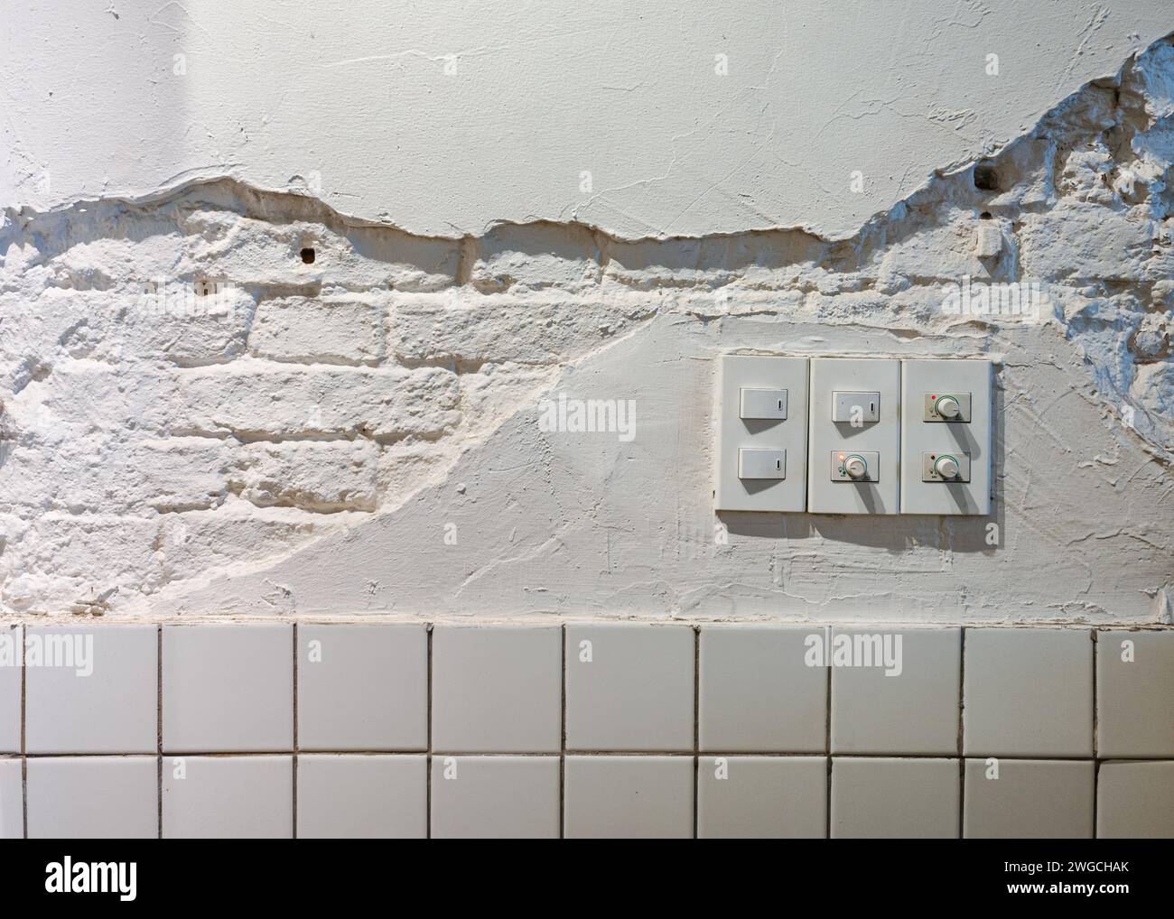 Light dimmer switch with light switch on cracked wall Stock Photo - Alamy