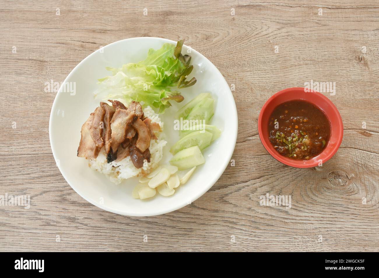 slice grilled pork neck topping rice with cucumber and garlic dipping ...