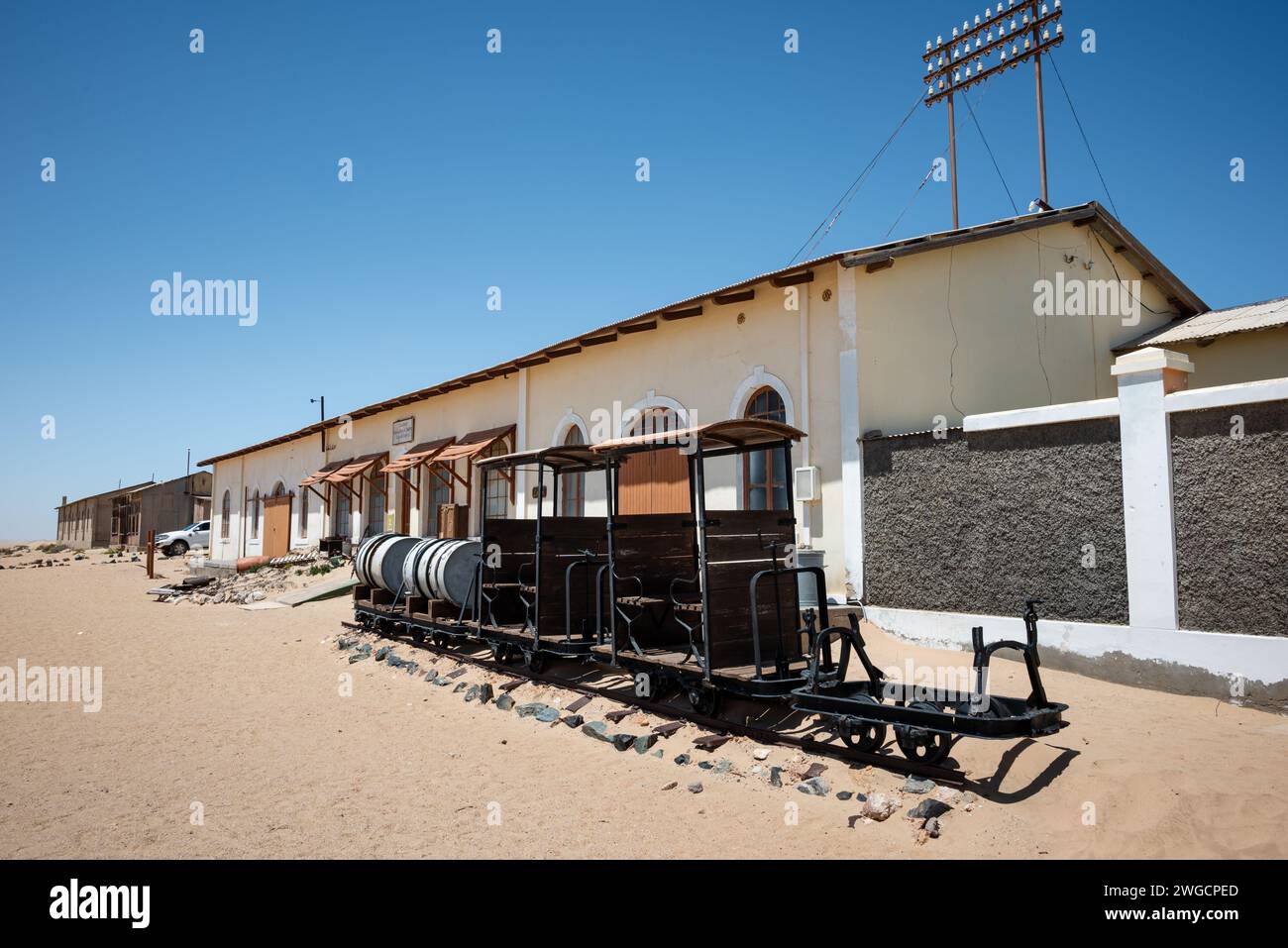 Train passing by buildings in a desert landscape Stock Photo - Alamy