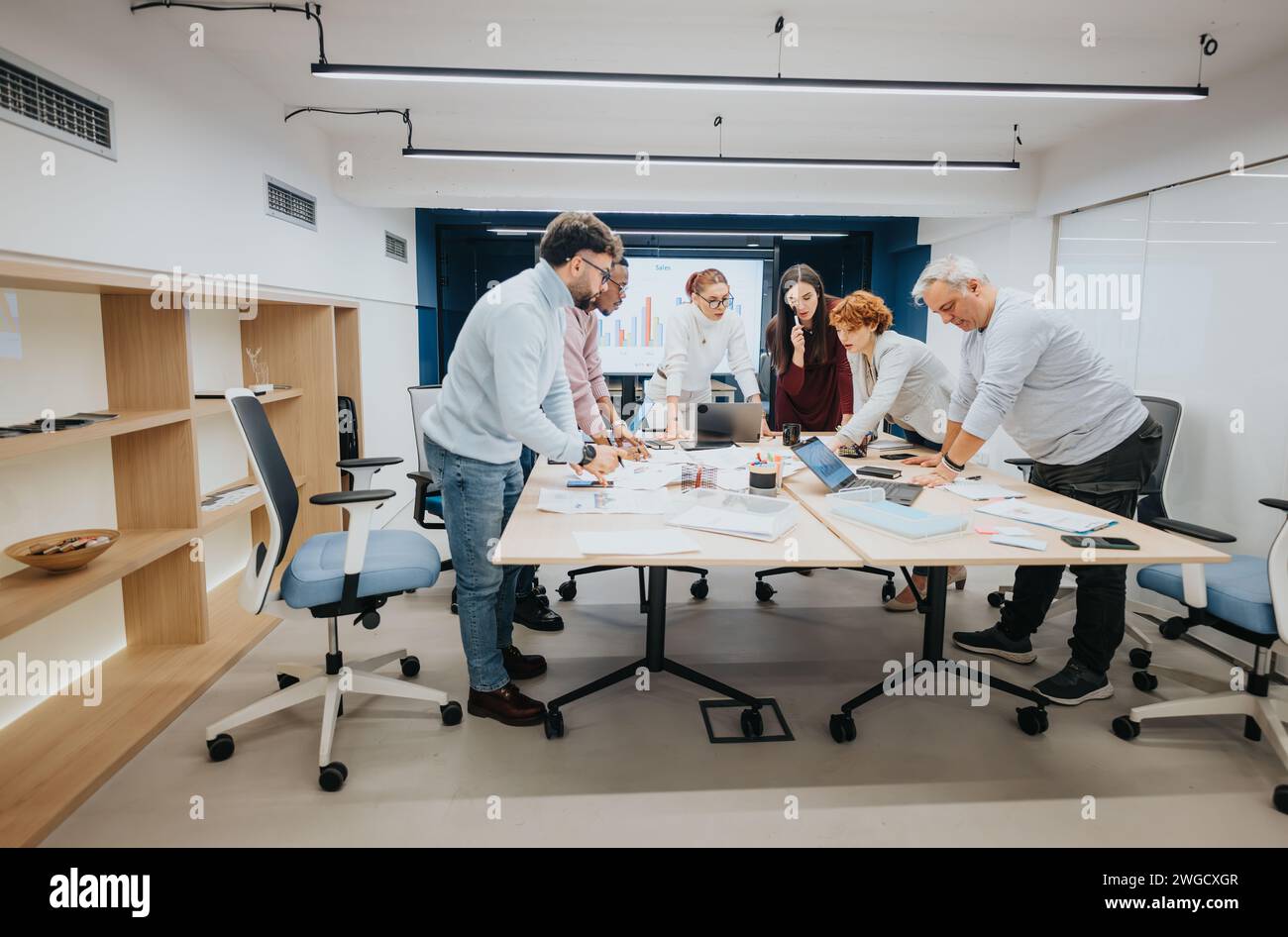 Successful businesspeople collaborating and discussing statistics in a ...