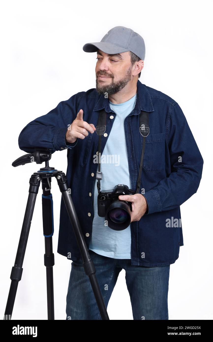 Male photographer posing with modern digital SLR camera and tripod ...