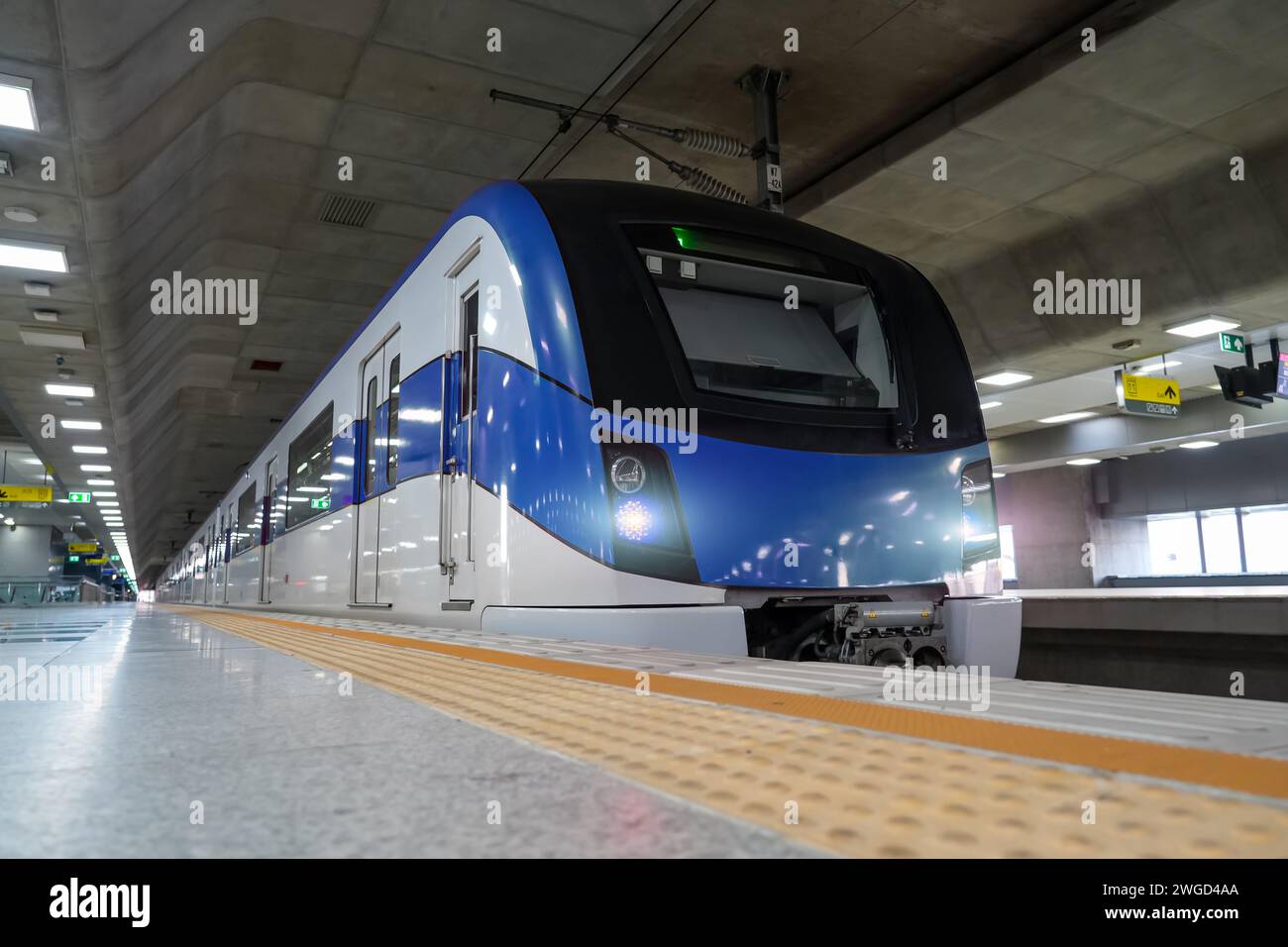 High speed electric train with bright headlights on at a station near ...
