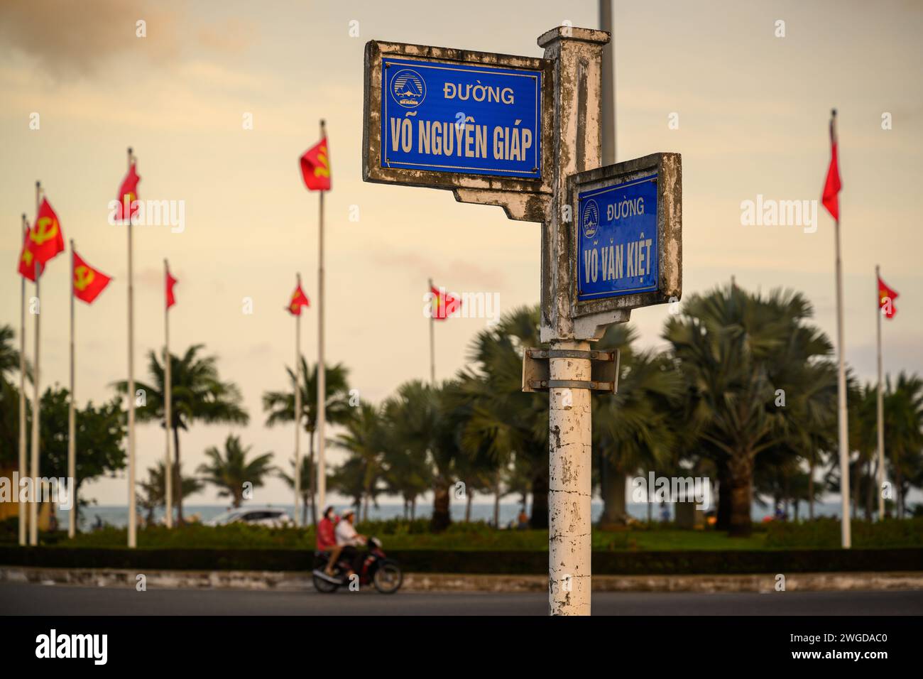 Vietnamese road signs with Vietnamese flags in the background at sunset ...