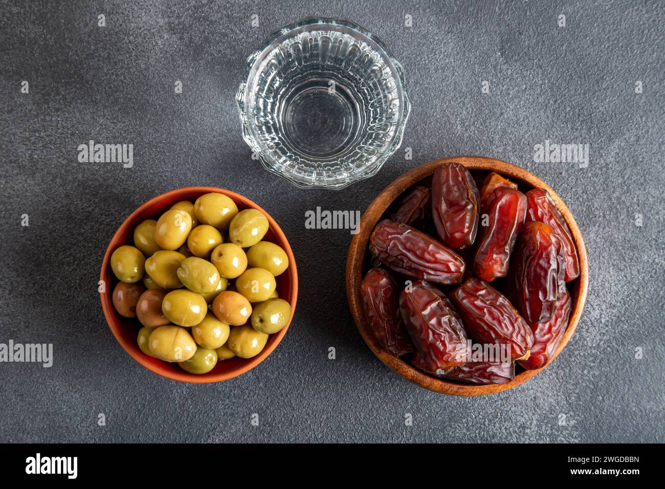 Traditional iftar table with dates, green olives and a glass of water ...