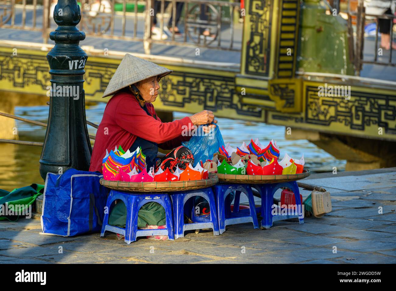 An elderly lady selling lanterns by the Thu Bon River, Hoi An, Vietnam ...