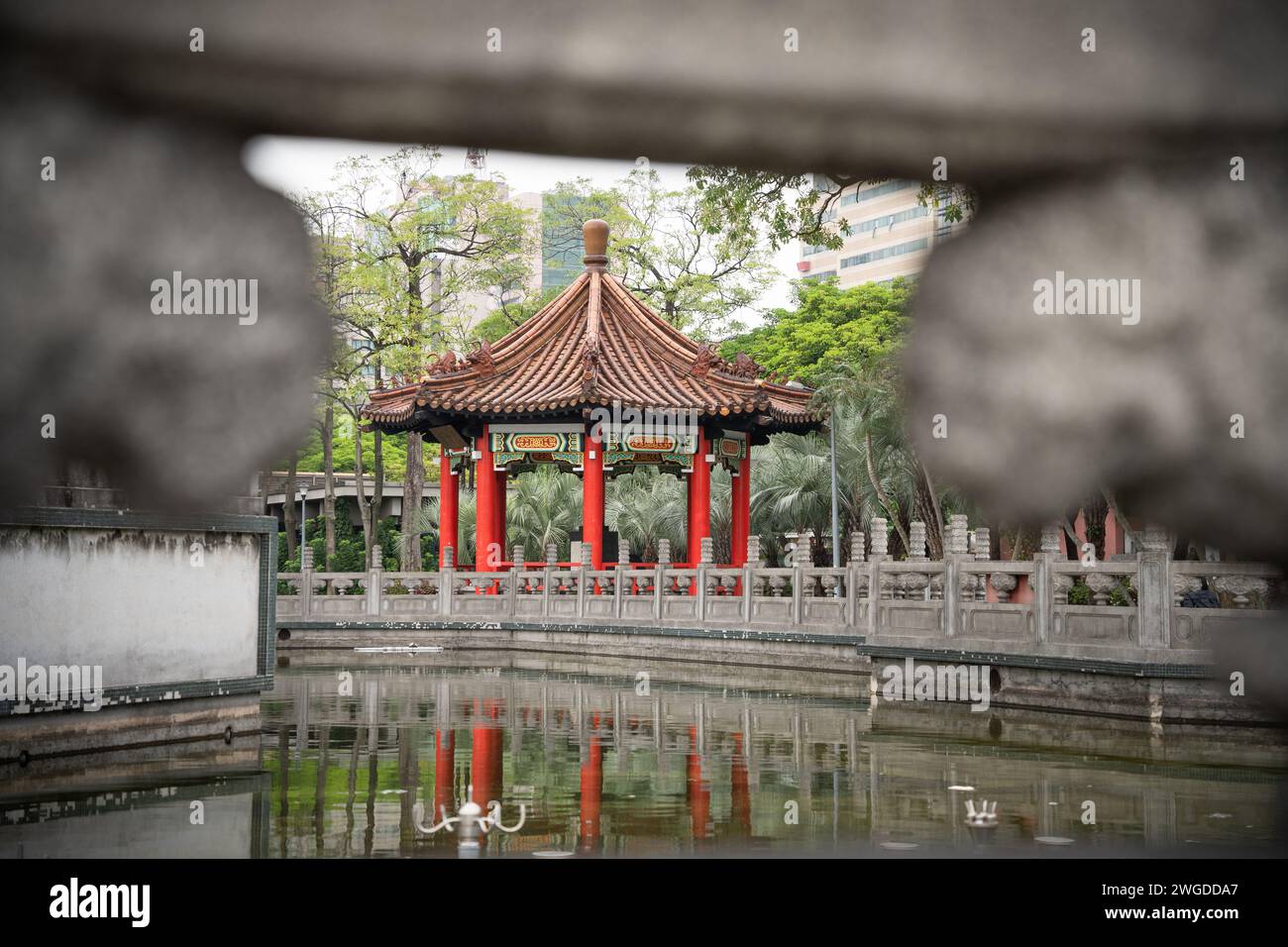 Traditional Chinese building in a city park framed by a concrete ...