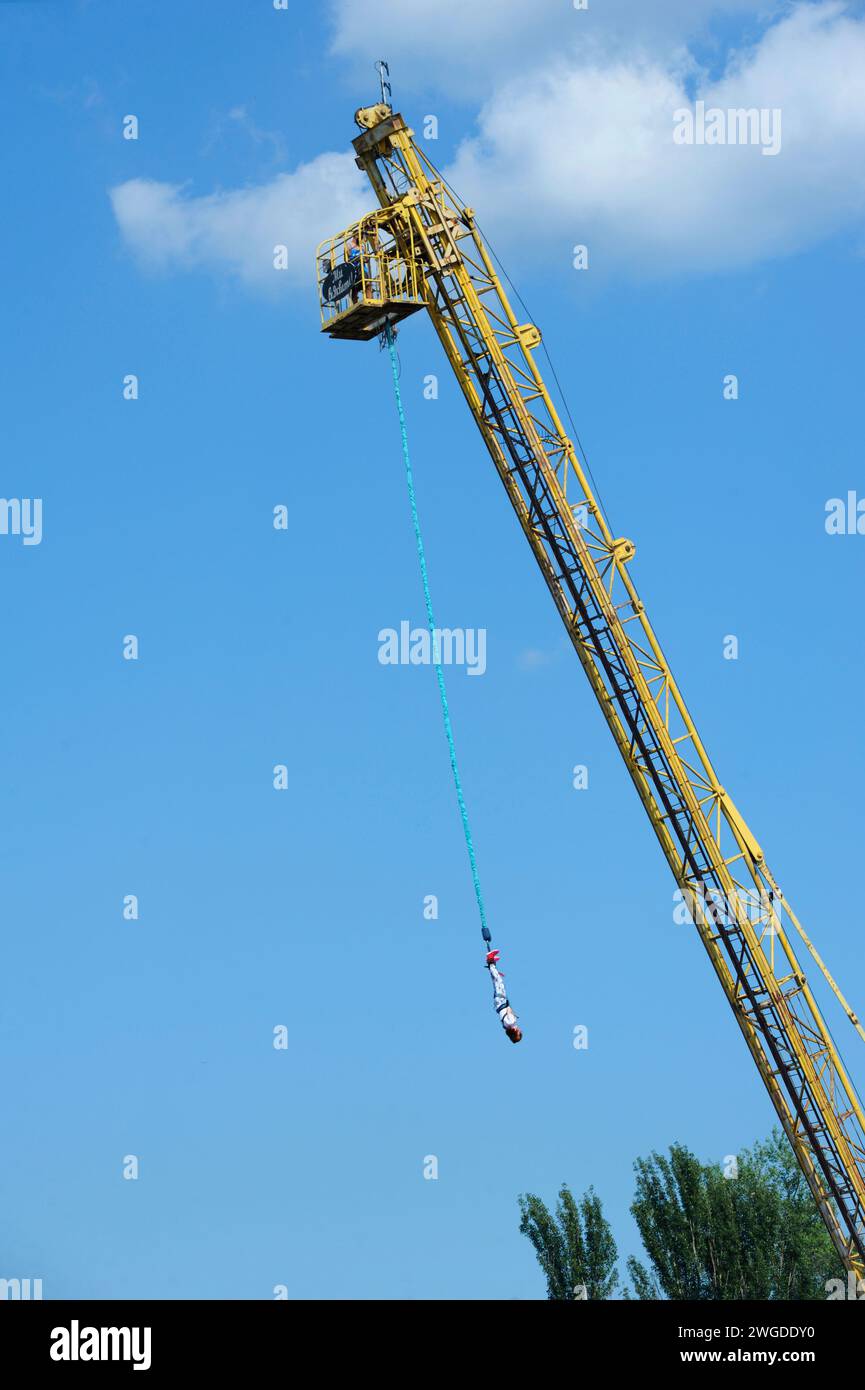 bungee jumping. Young woman jumping from the high rise tower crane ...