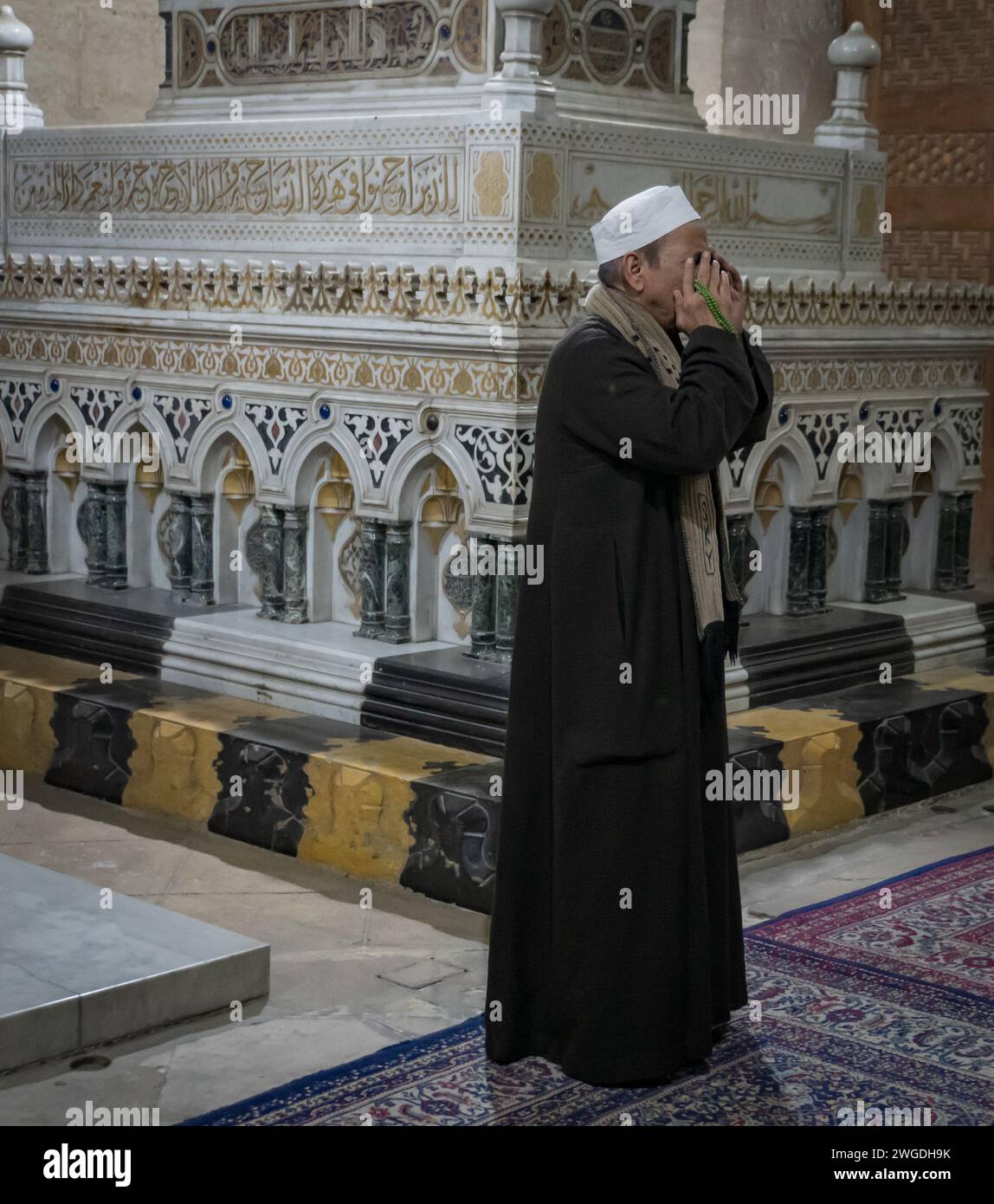 Muezzin: the Muslim man holding hands before his mouth as he sings the ...