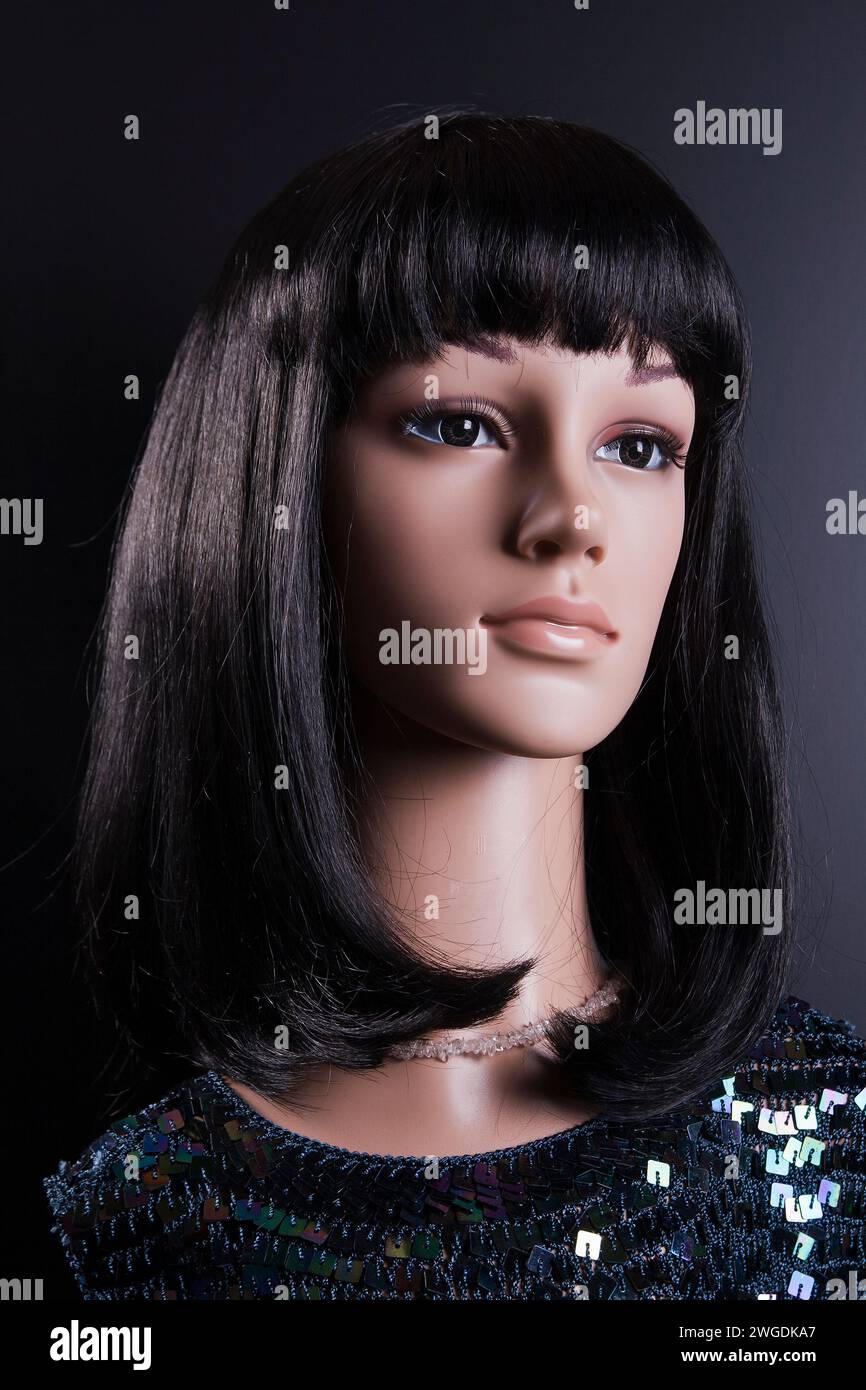Plastic woman mannequin with long black hair and sequins top posing on ...