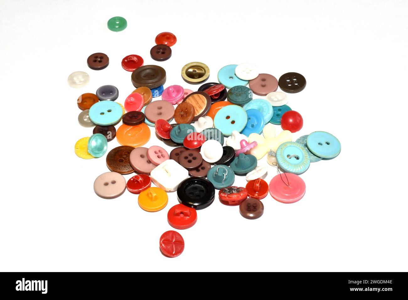 Colored buttons of different sizes lie in a pile on a white background ...