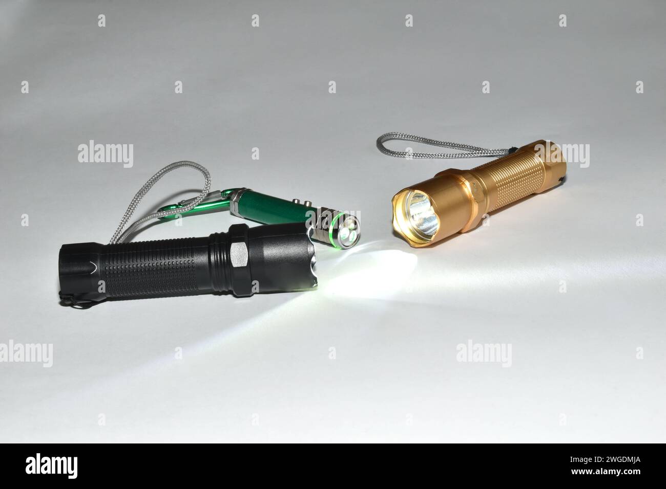 There are three switched-on flashlights on the table surface Stock ...