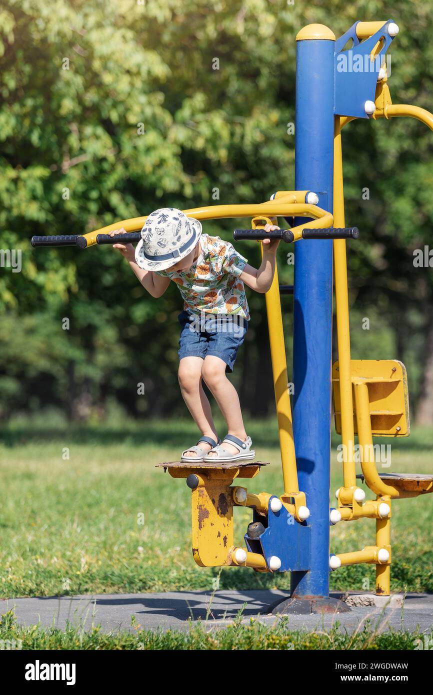 An active and very energetic little boy is trying to overcome and lift ...