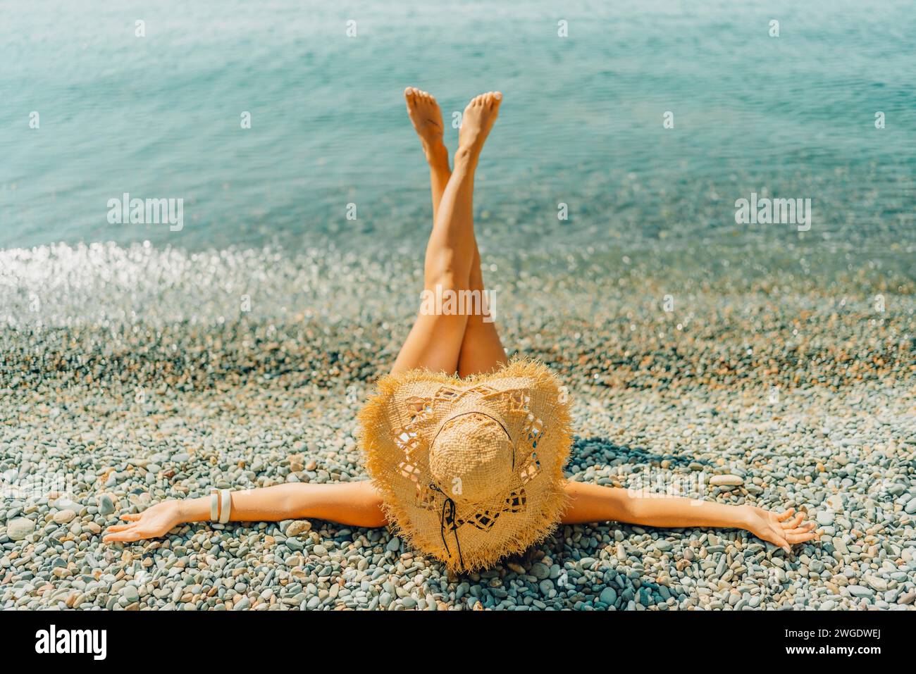 Beach Relaxation Woman Lies On A Pebble Beach Legs Raised And Arms