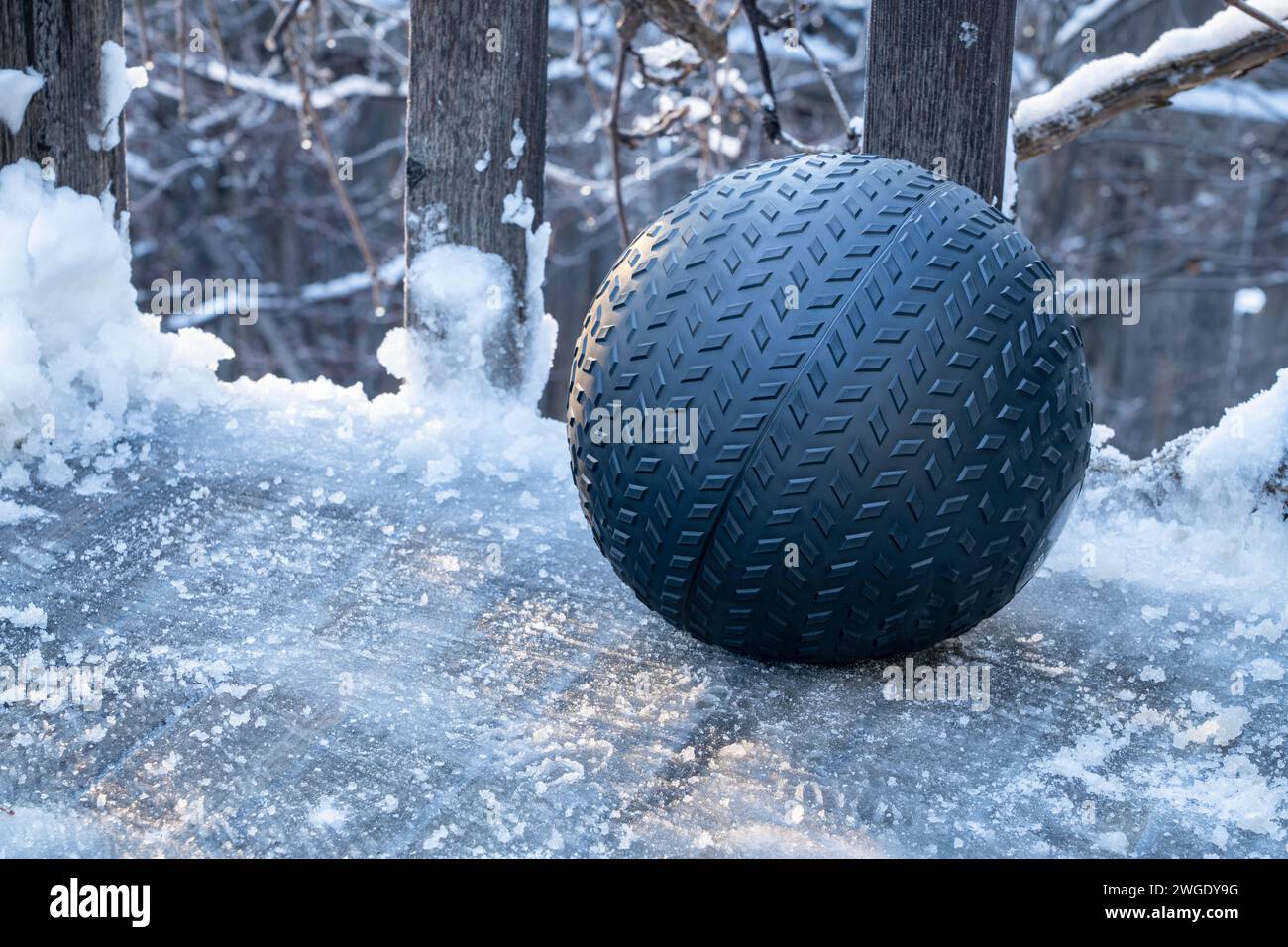 heavy, 50 lb, slam ball filled with sand on an icy backyard deck ...