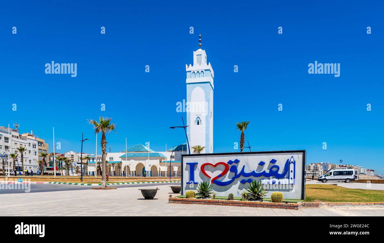A bustling city street lined with towering buildings in Fnideq, Morocco ...