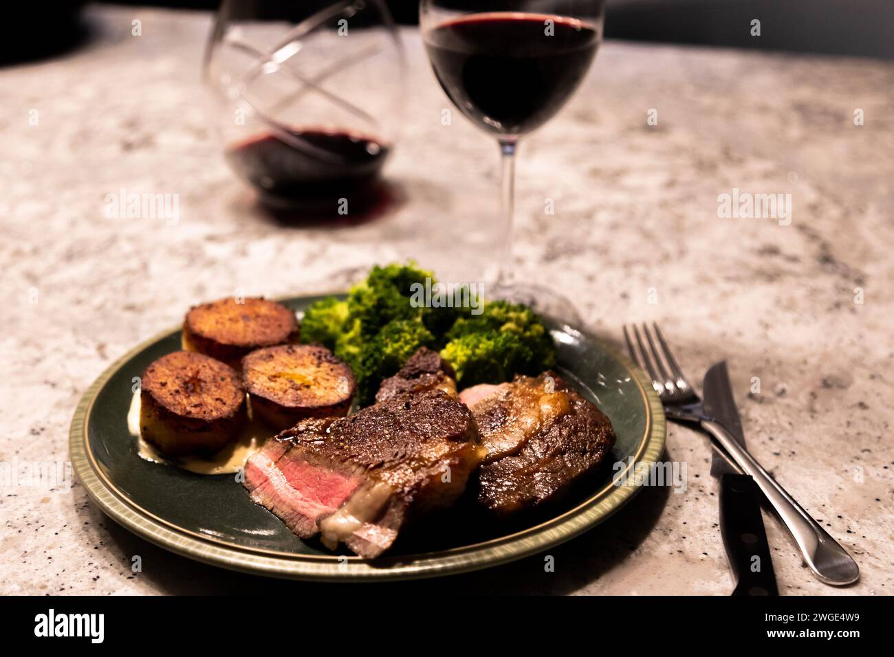 Rib eye steak with potatoes and broccoli and a glass of red wine ...