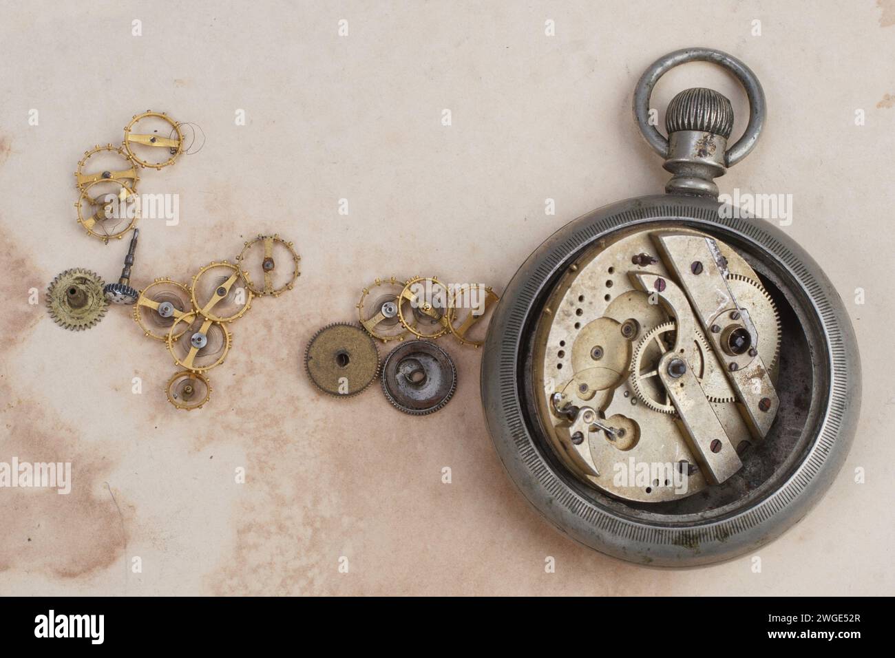 broken vintage pocket watch on dirty paper background Stock Photo - Alamy