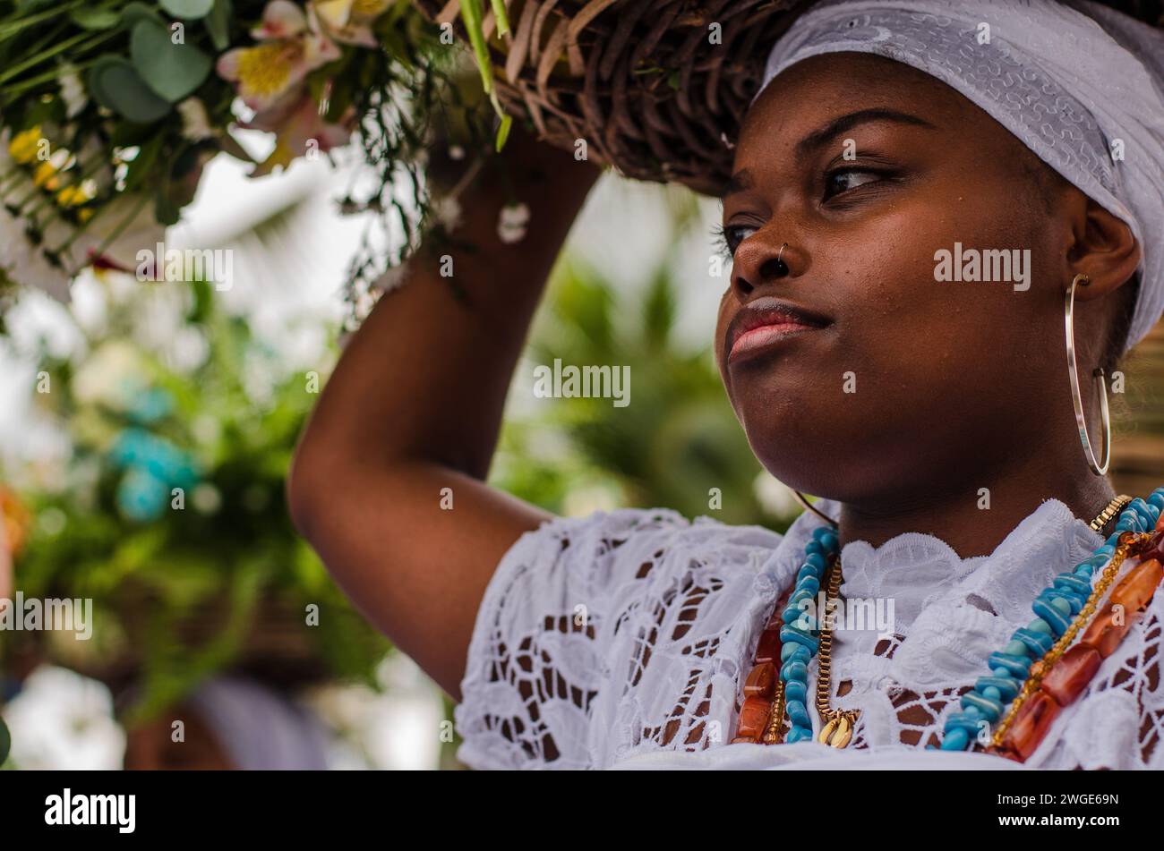 A female devotee carries flowers to offer to Iemanjá on Iemanjá's day ...