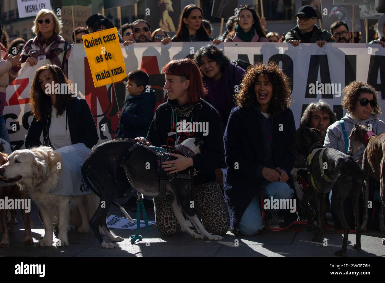 A group of protesters with their dogs participate during a ...