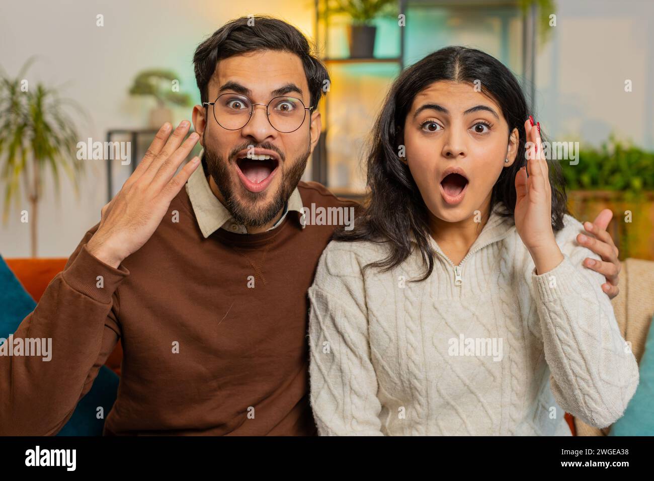 Portrait of amazed shocked couple with wow reaction open mouth looking ...