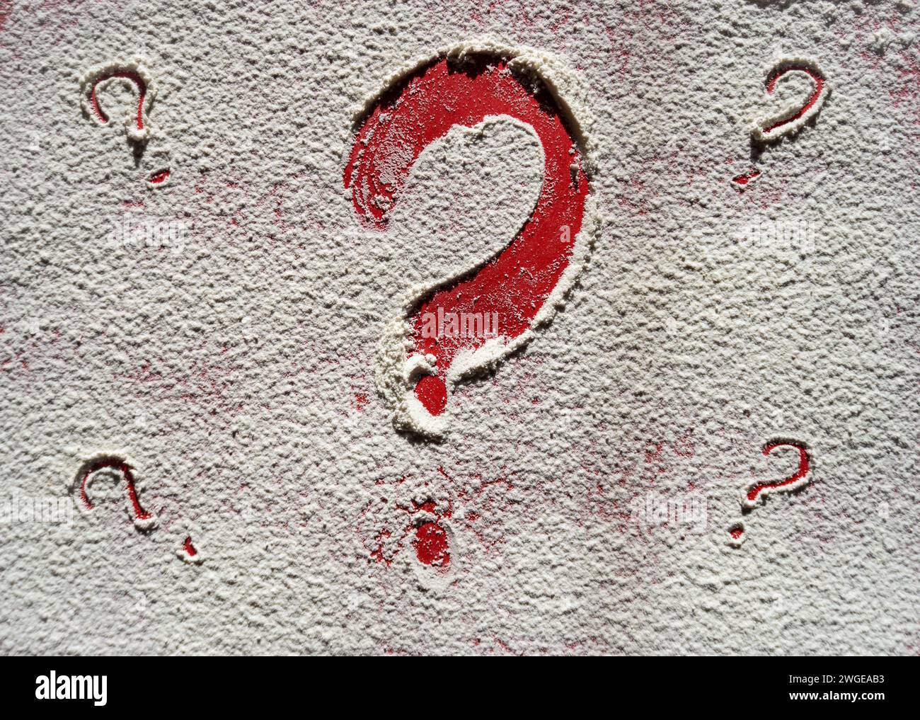 Drawn question mark on red background, drawn on flour. Question mark ...
