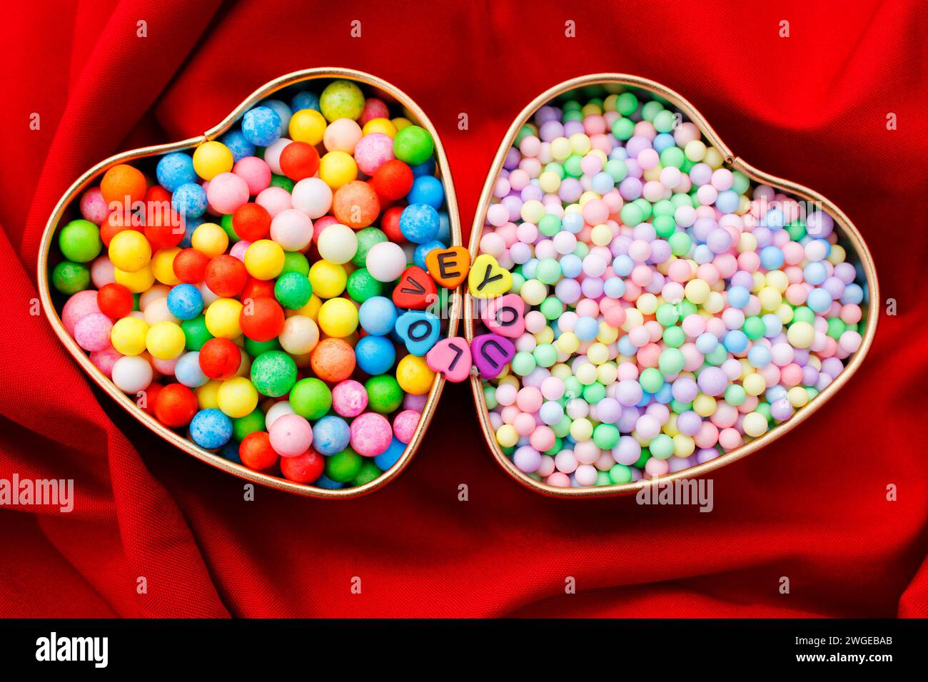 Phrase love you on two golden heart shaped containers Stock Photo - Alamy