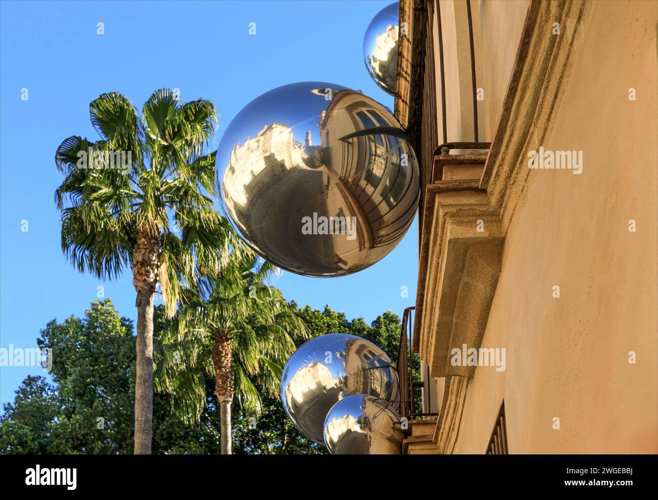 Large silver christmas balls on the outside of a Spanish building with ...