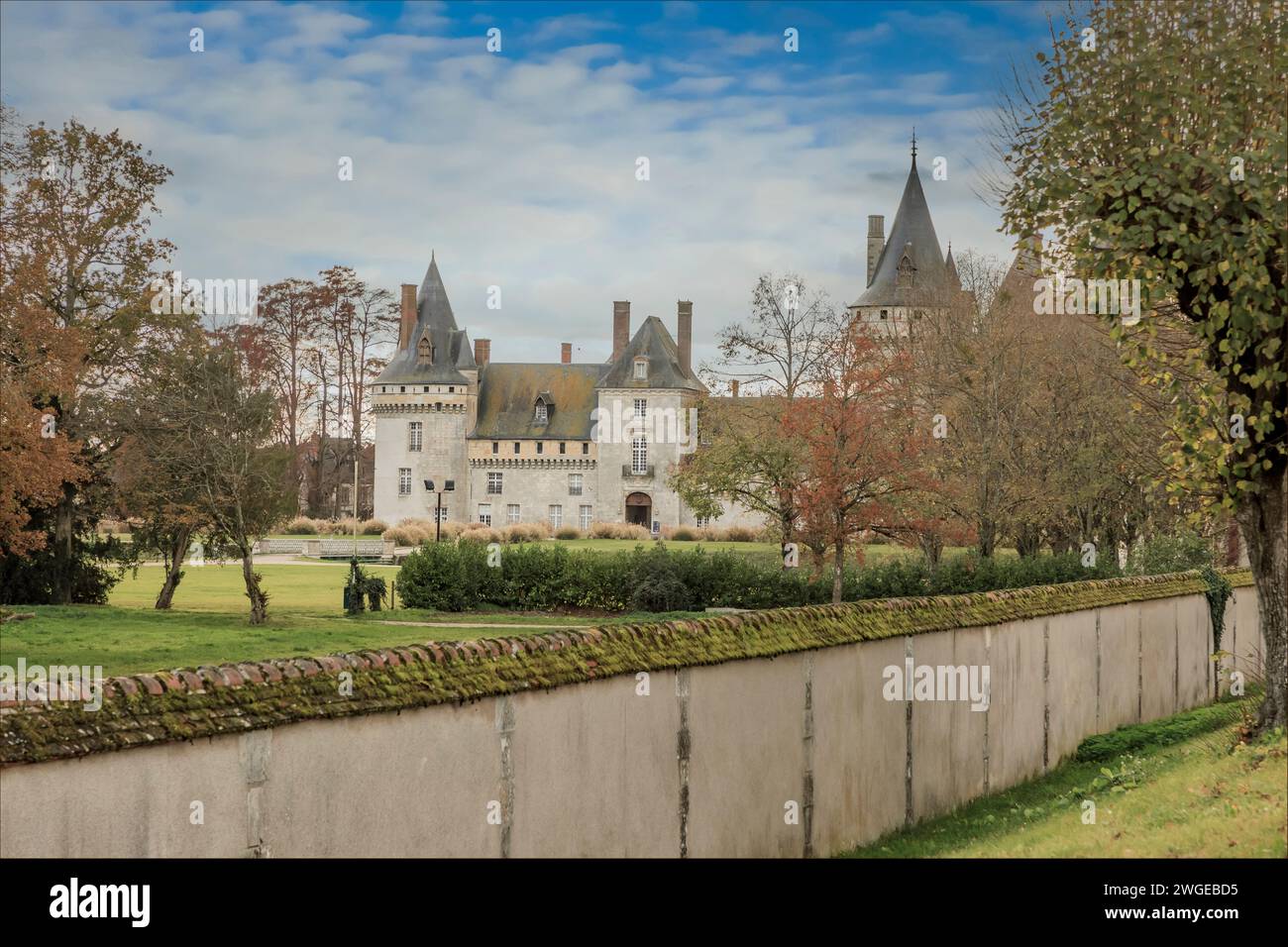 Looking over a wall across ornate gardens at a french castle in the ...