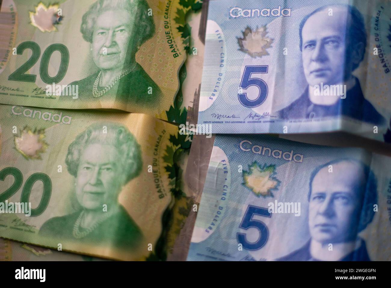 Canadian currency. Five and twenty Canadian dollar notes spread on a ...