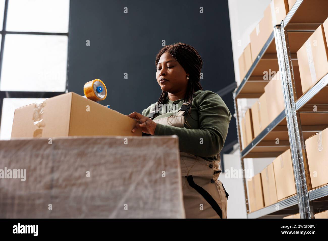 African worker taping boxes hi-res stock photography and images - Alamy
