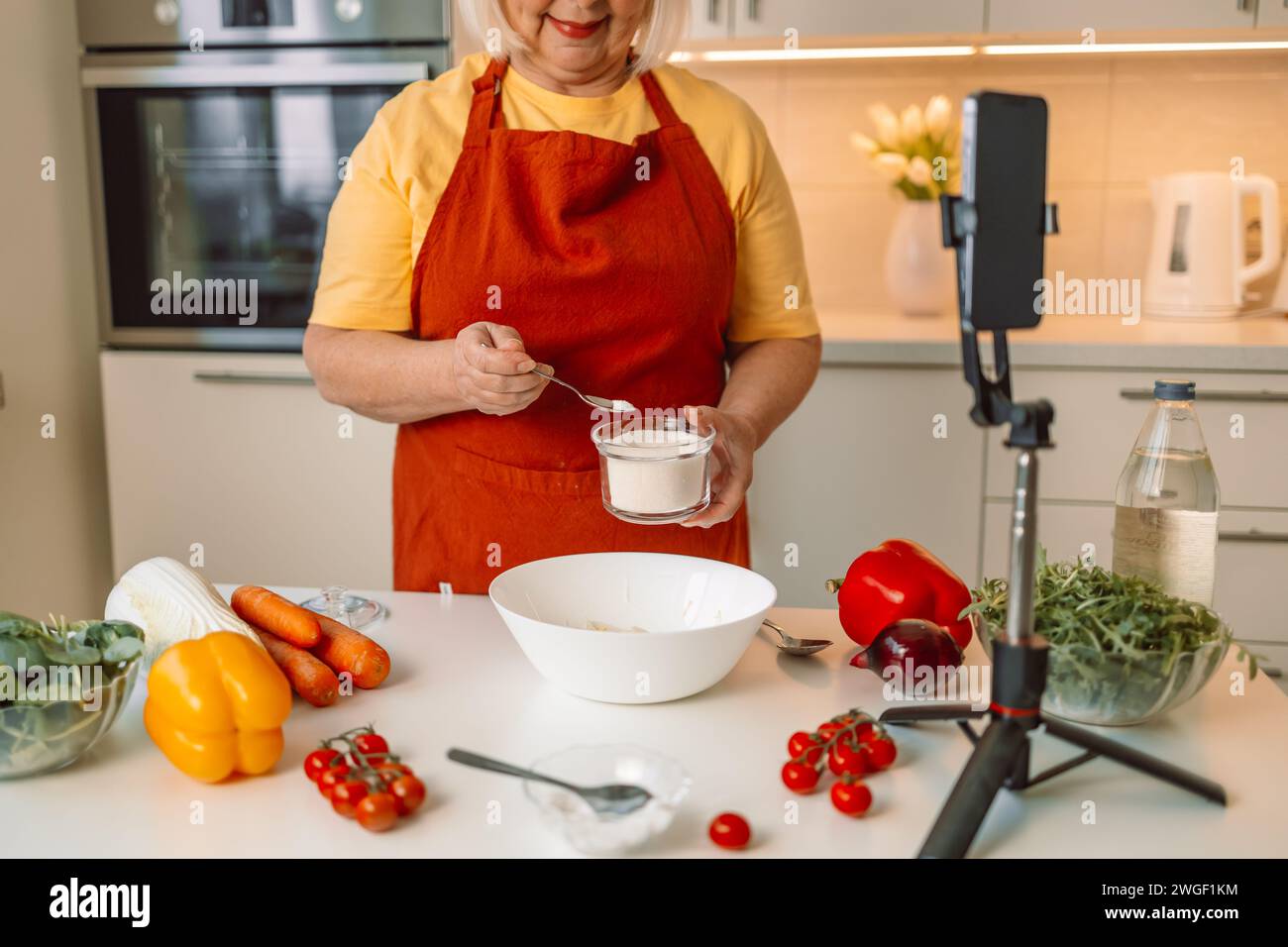 Online cooking tutorial. Caucasian woman using smart phone for vlogging ...
