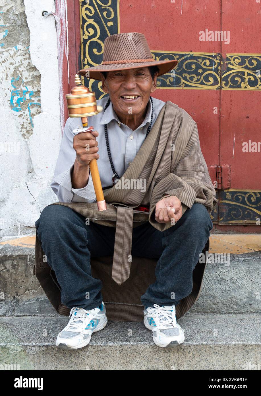 Old tibetan man sitting by wall hi-res stock photography and images - Alamy