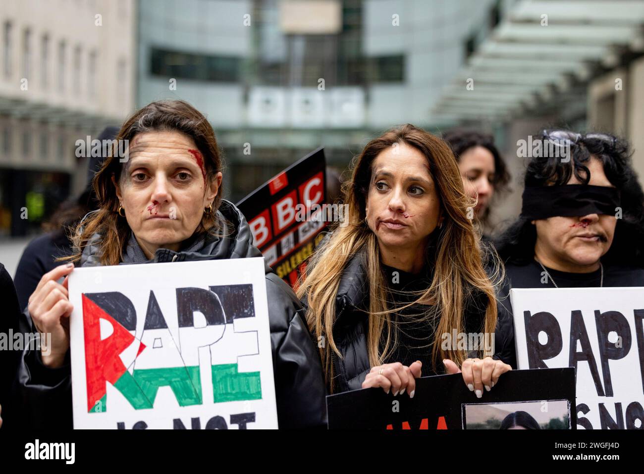 Female protesters cover their eyes and wear artificial wounds make-up ...