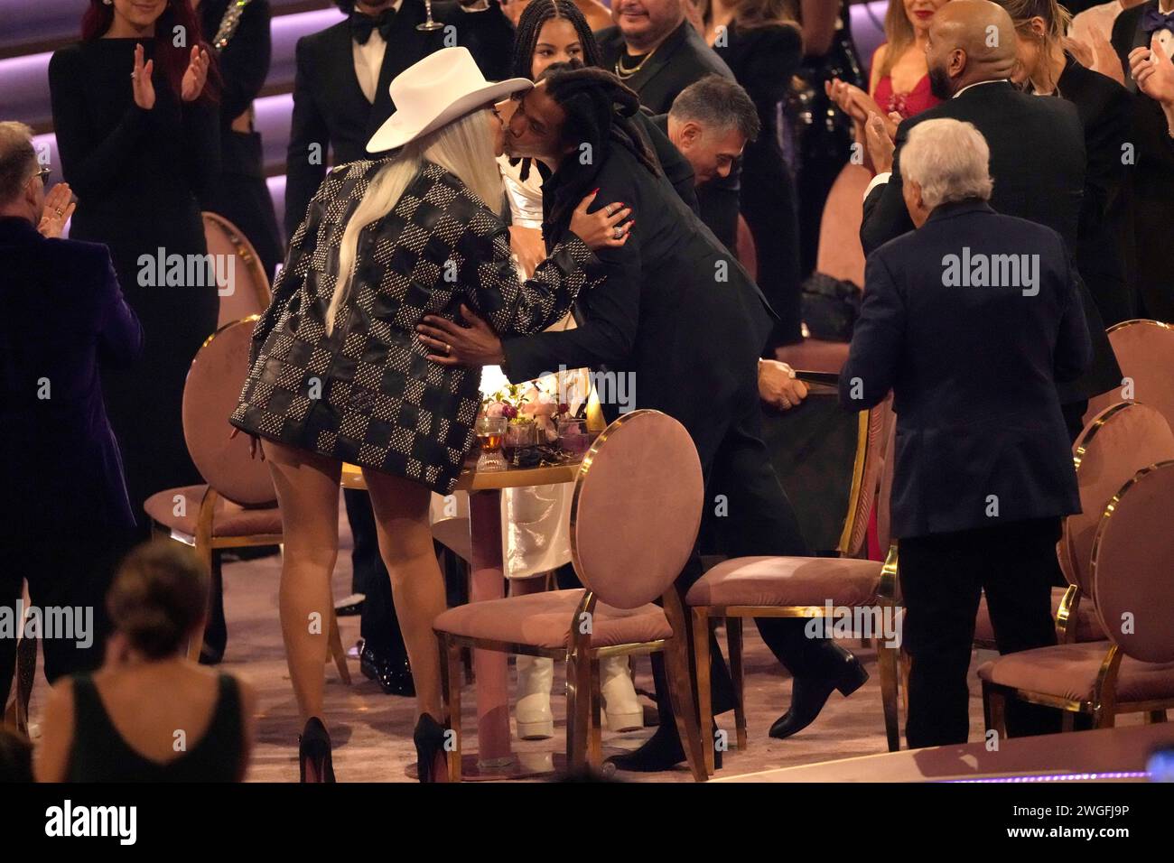 Beyonce, left, and Jay-Z kiss in the audience as Jay-Z is given the Dr ...