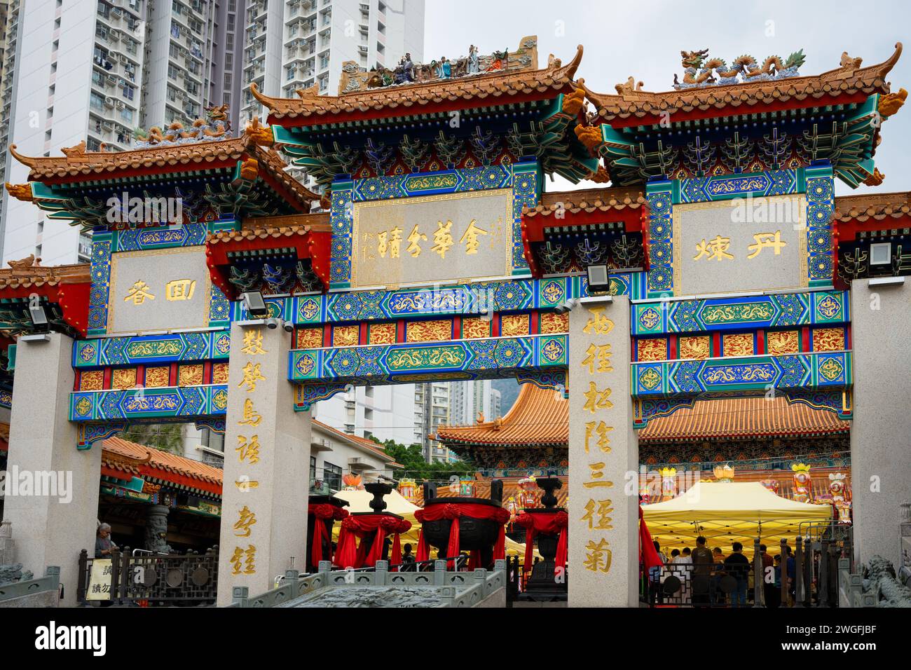 Colorful gate on city street, people walking below Stock Photo - Alamy