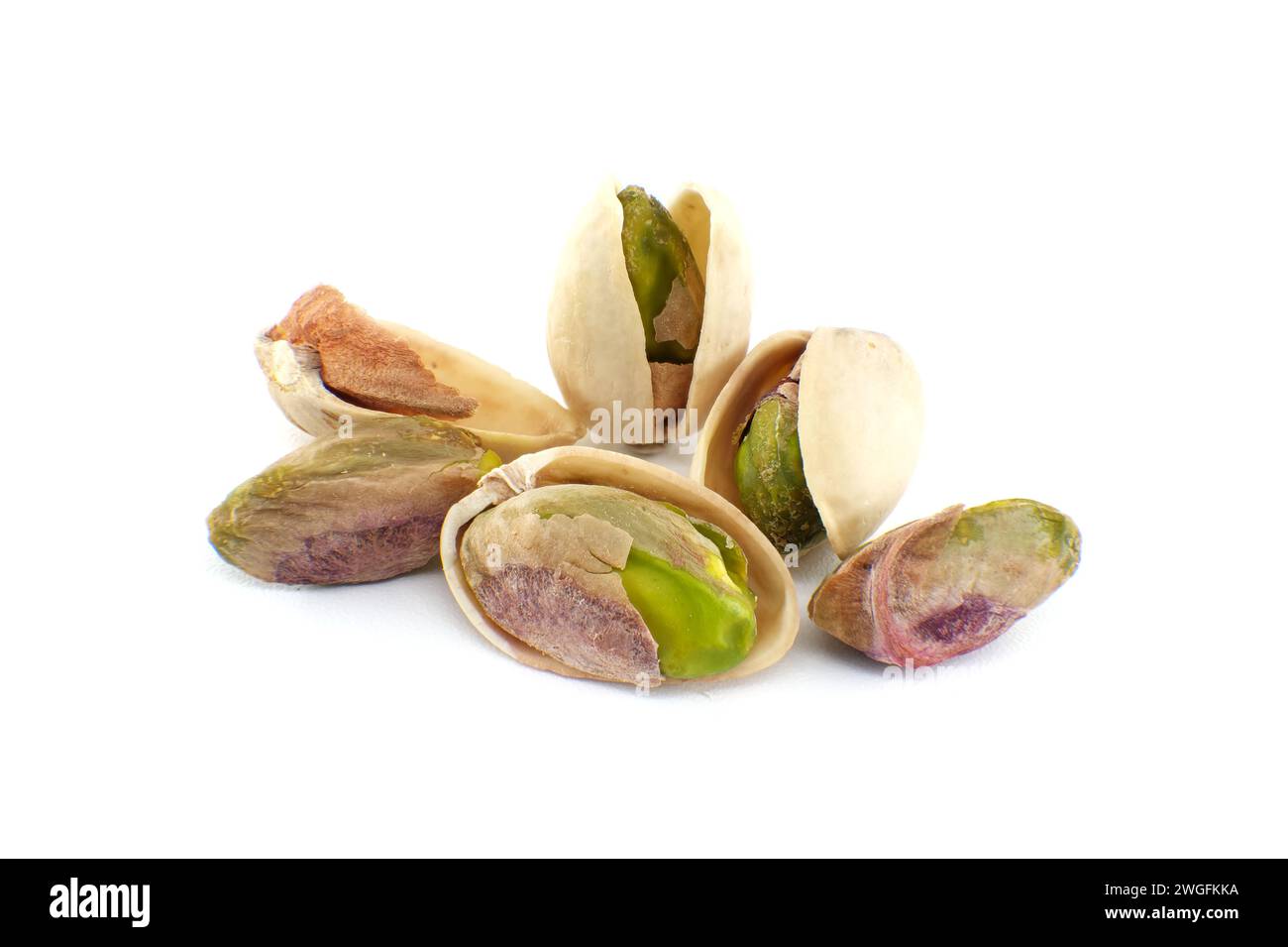 Pistachios in-shell and others peeled exposing the green nuts inside ...