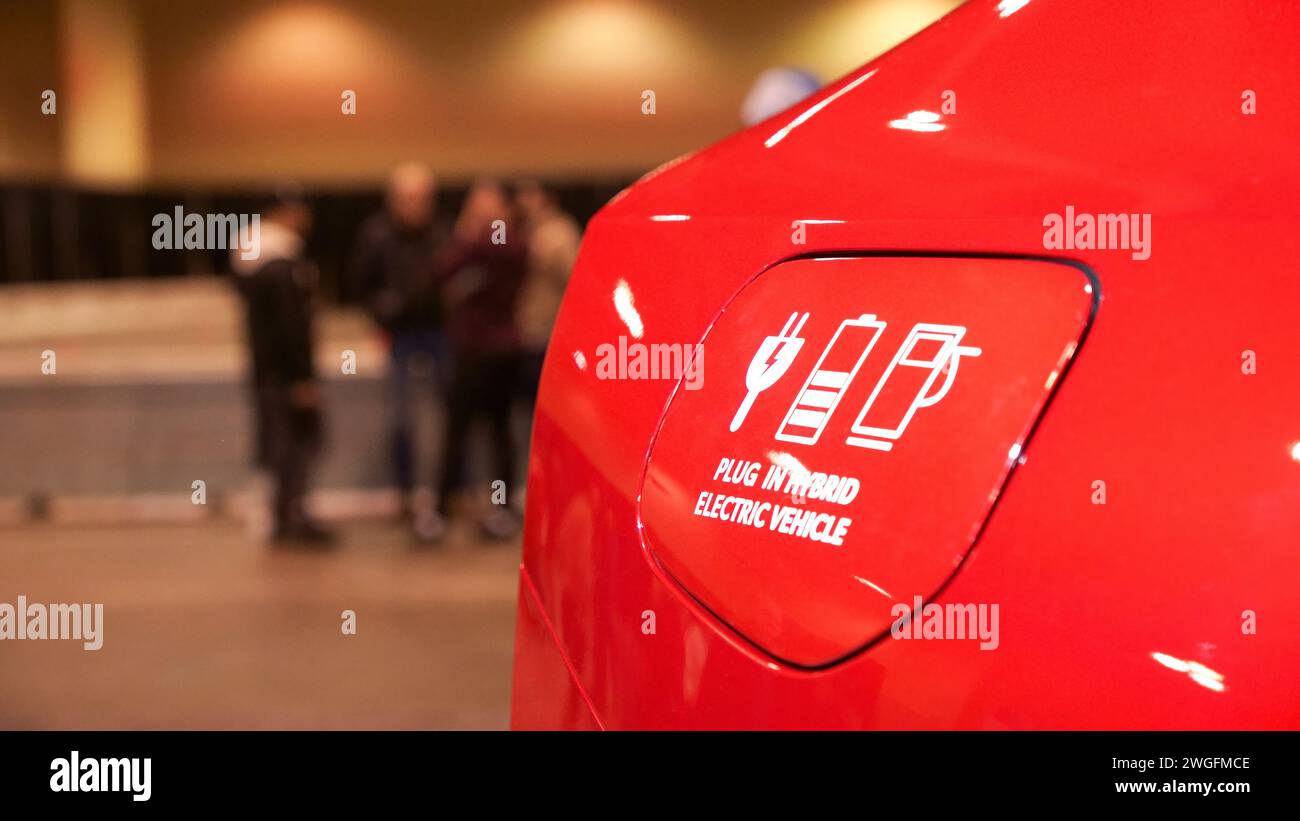 New plug-in hybrid electric vehicle models at Auto show. Red car on ...