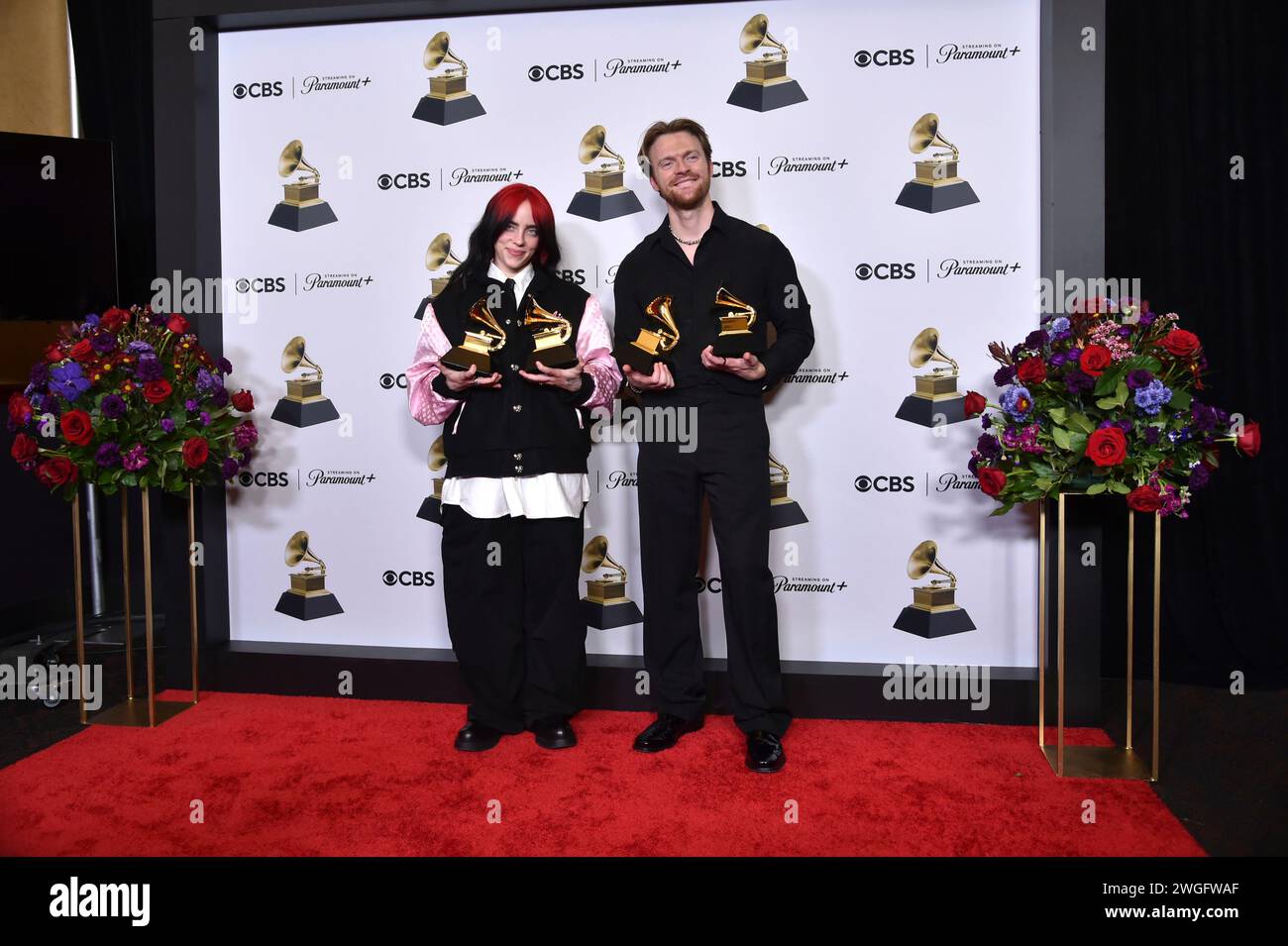 Billie Eilish, left, and Finneas pose in the press room with the awards ...