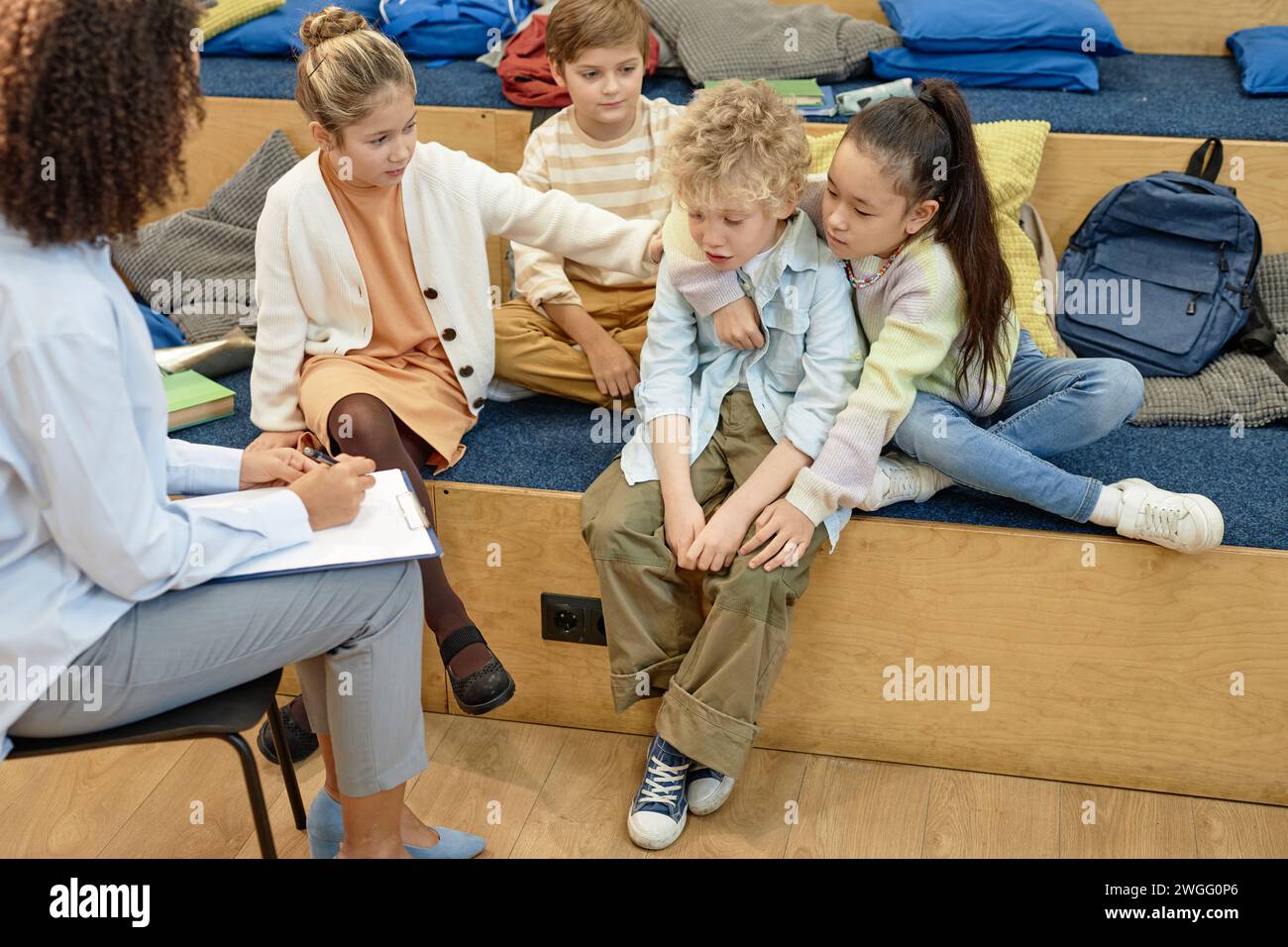 Full length view at group of children supporting little boy during ...