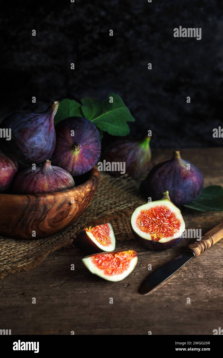 Fresh fig fruits in wooden bowl with cut pieces against vintage ...